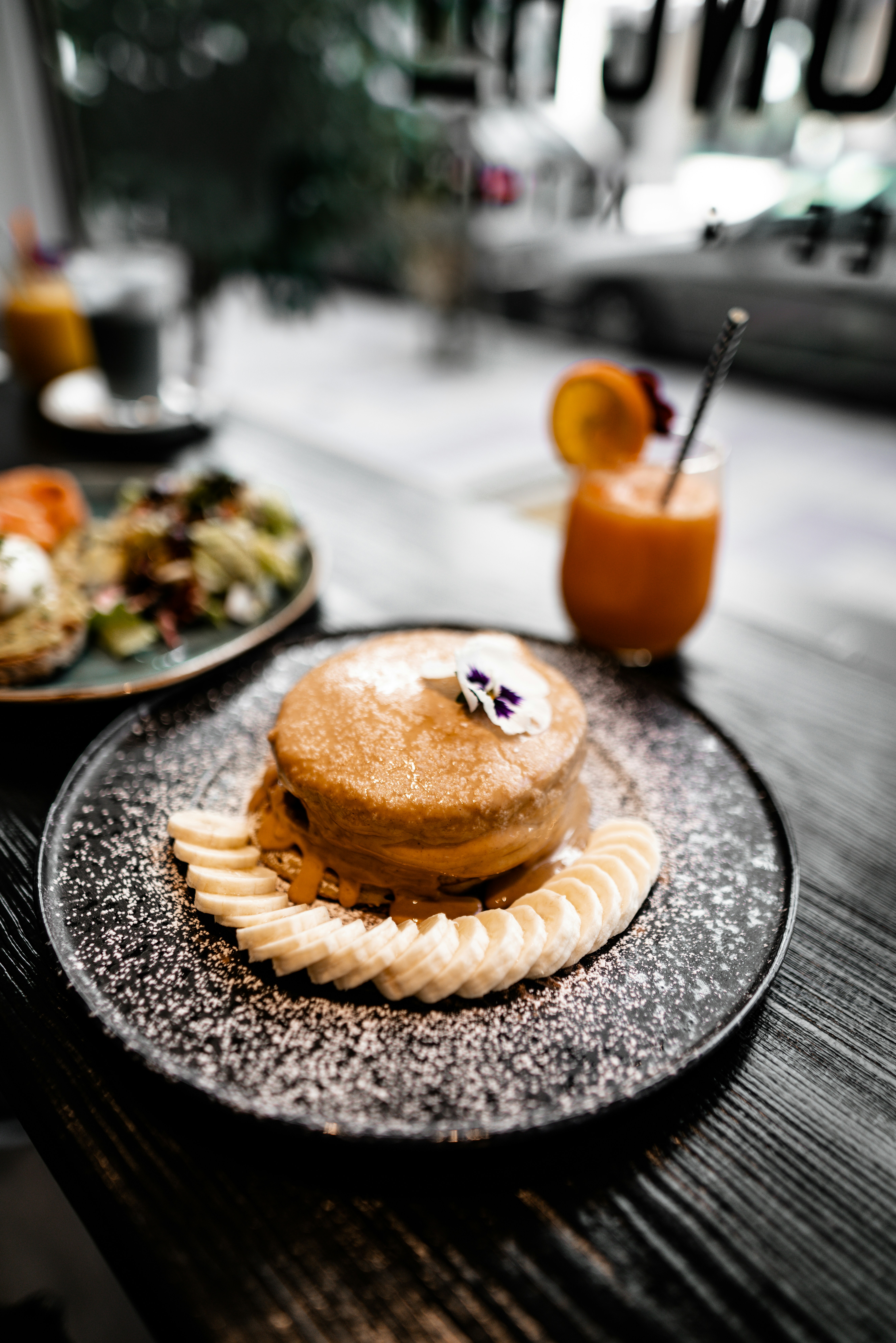 Cafe Dessert Centerpiece: A Fluffy Pancake with Cocoa Dust and Banana Ribbons