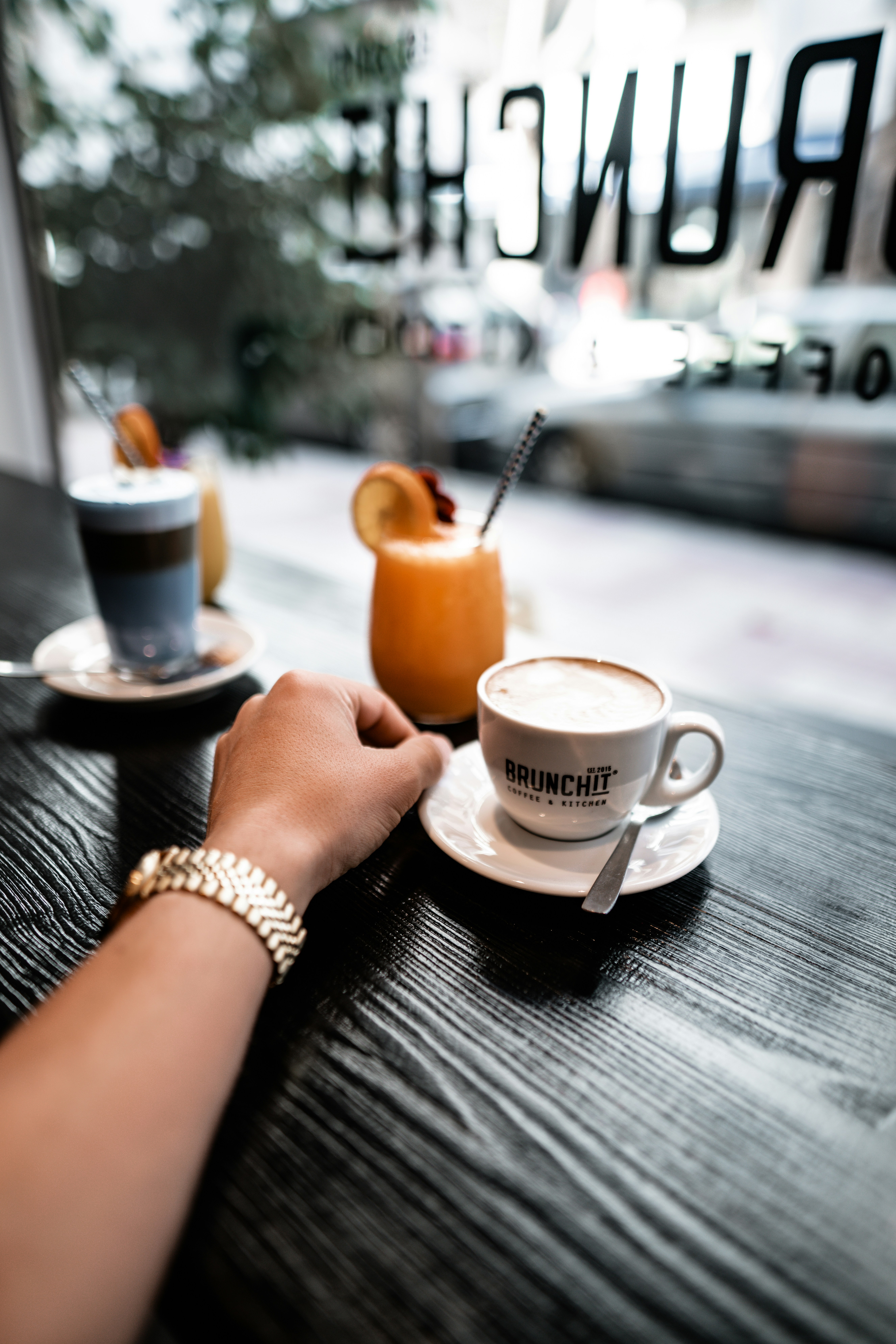 Brunch Ritual at the Café Window: A Hand, a Cup, and Morning Light