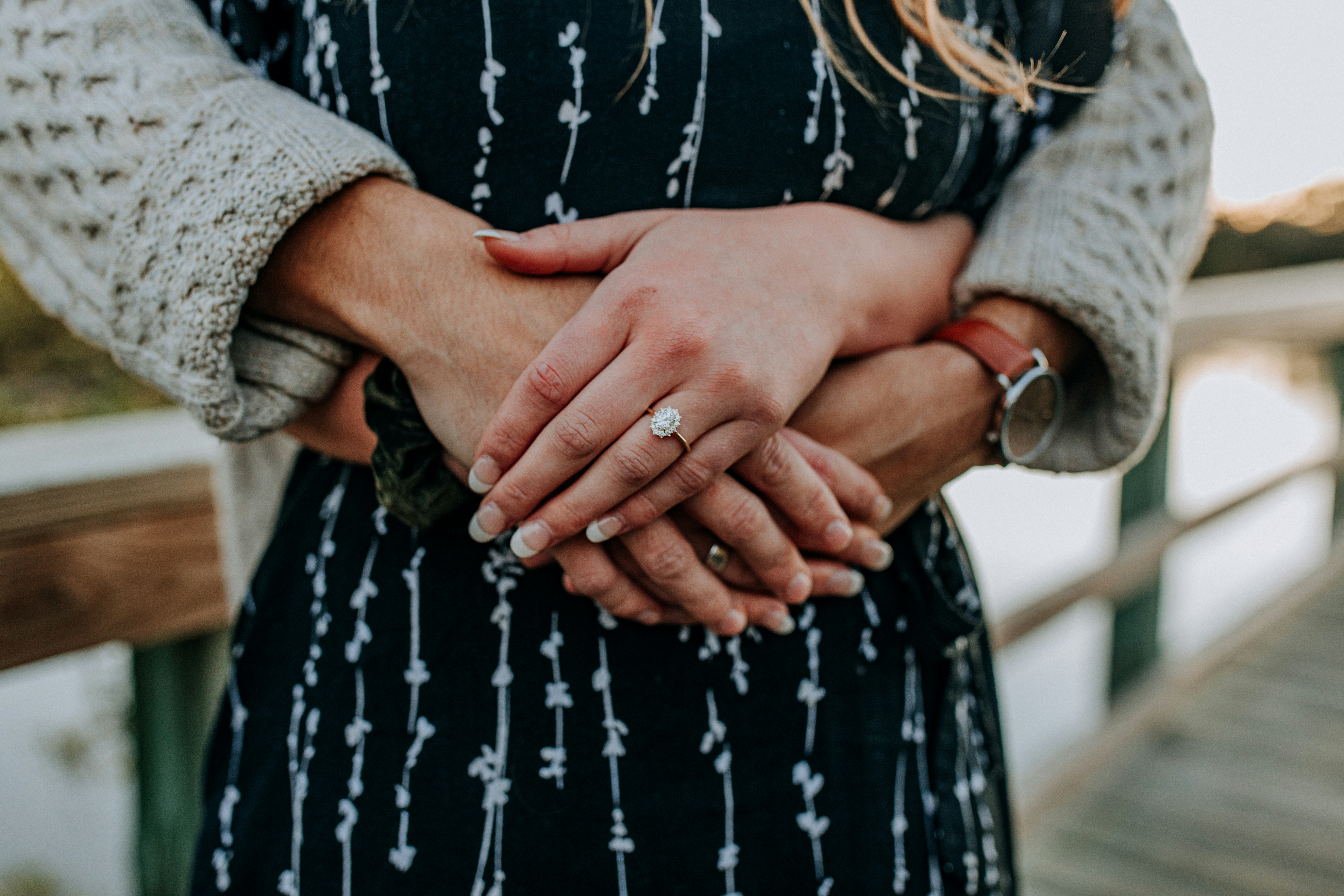 Persona abrazando a una mujer por la espalda en un puente de madera ...