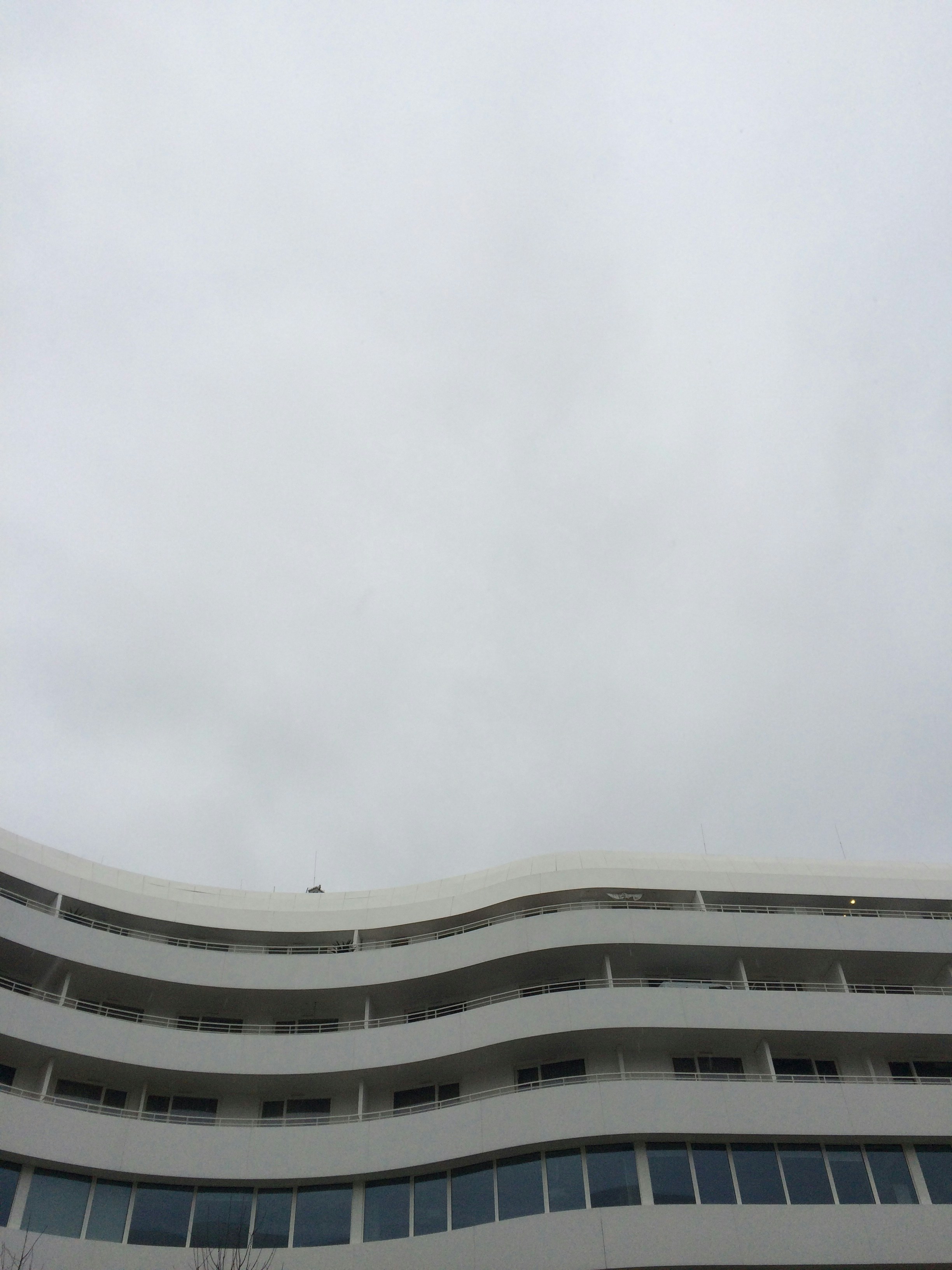 White modernist architecture on grey sky.