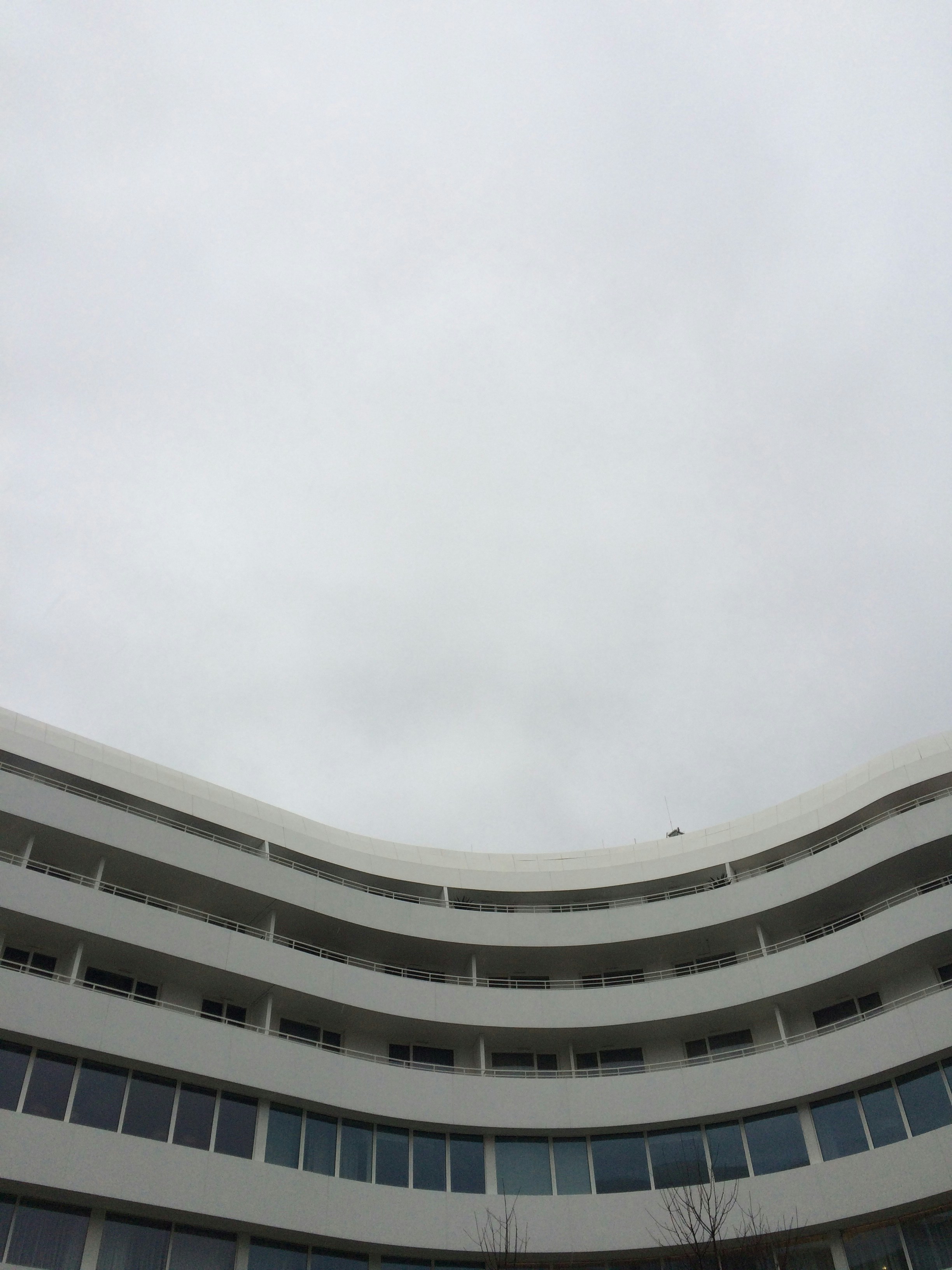 White modernist architecture on grey sky.