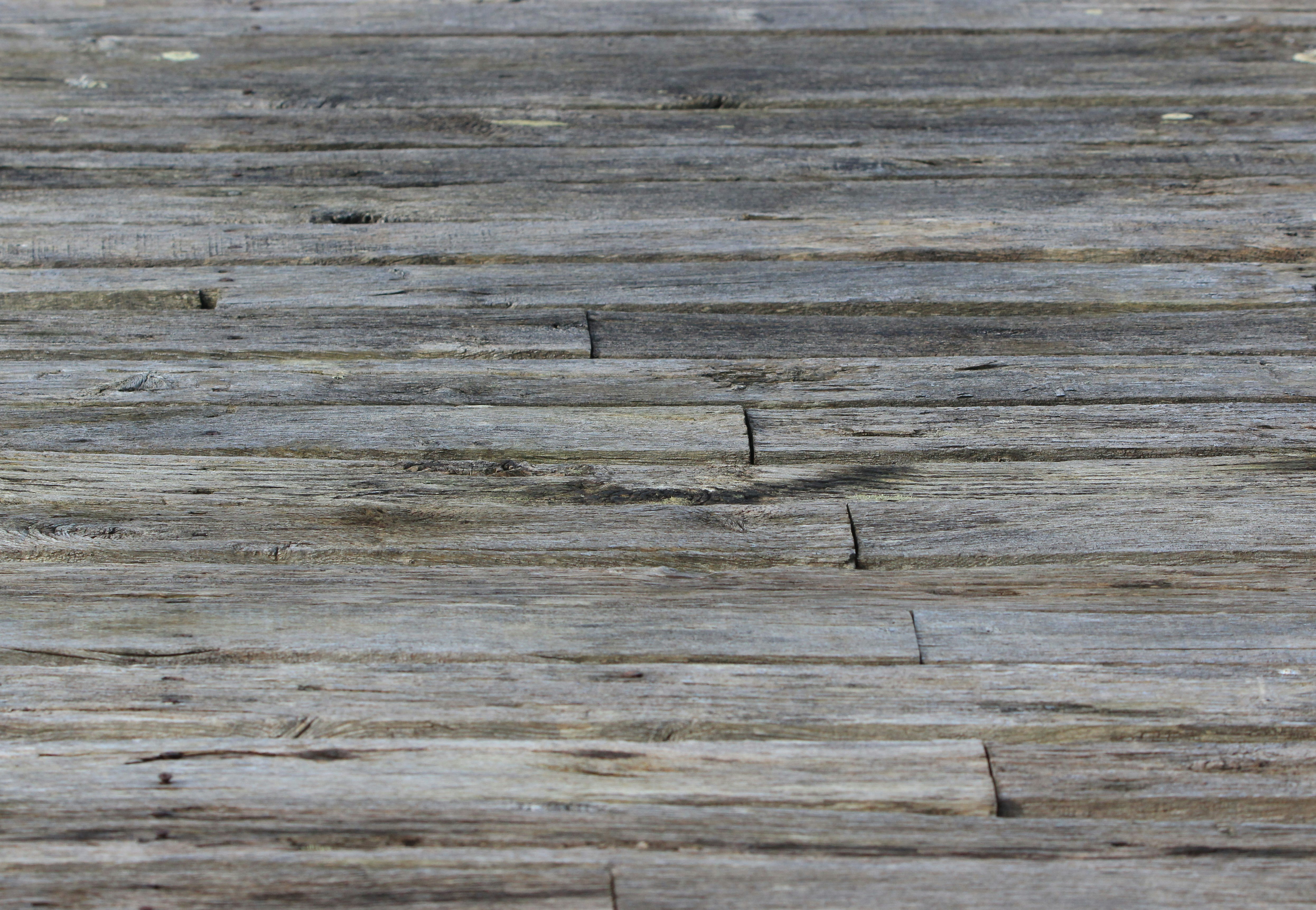 Close-up of weathered wooden planks showcasing intricate textures and natural aging. The image highlights the beauty of rustic materials.