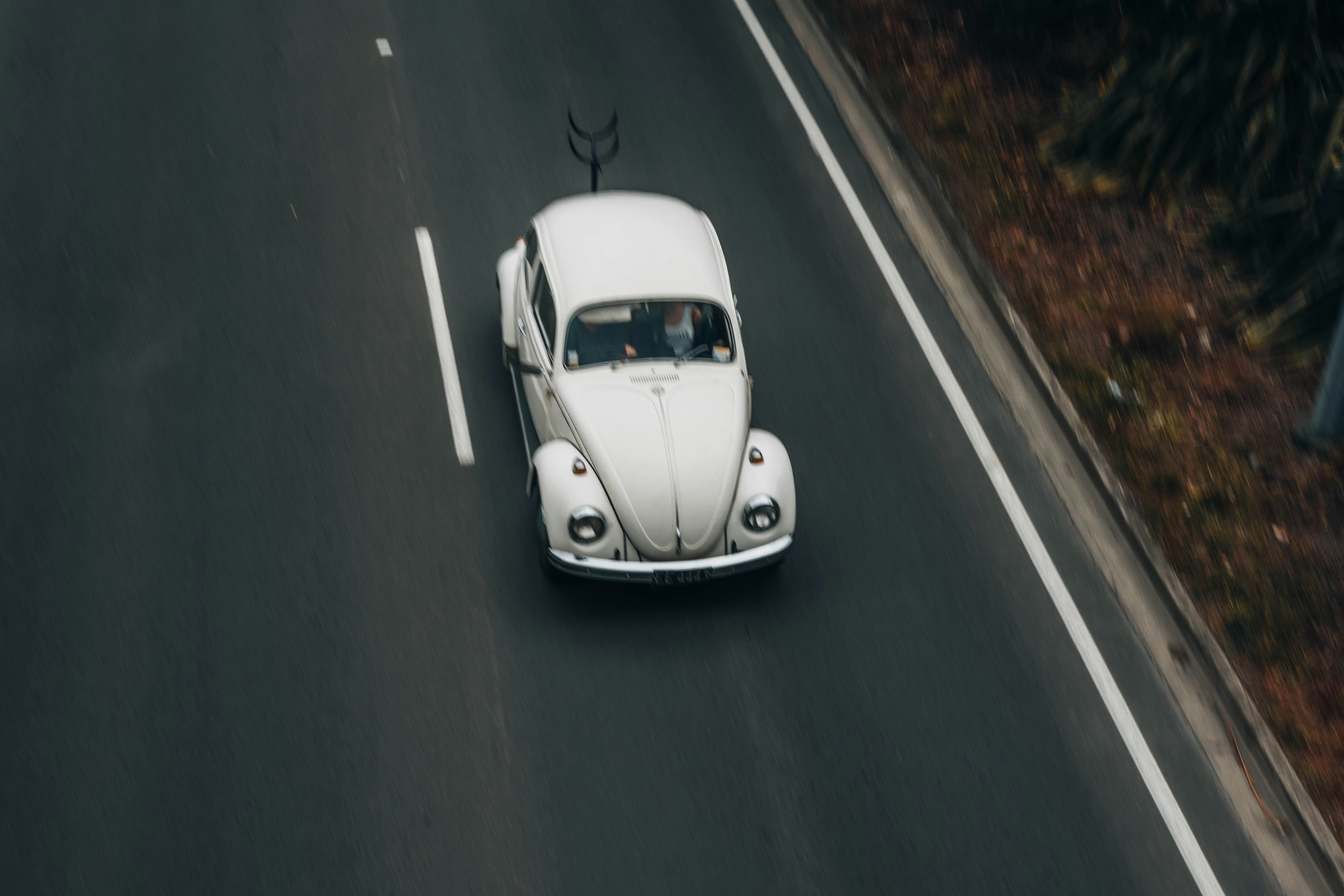 Overhead Portrait of a White Classic Car on a Serpentine Highway