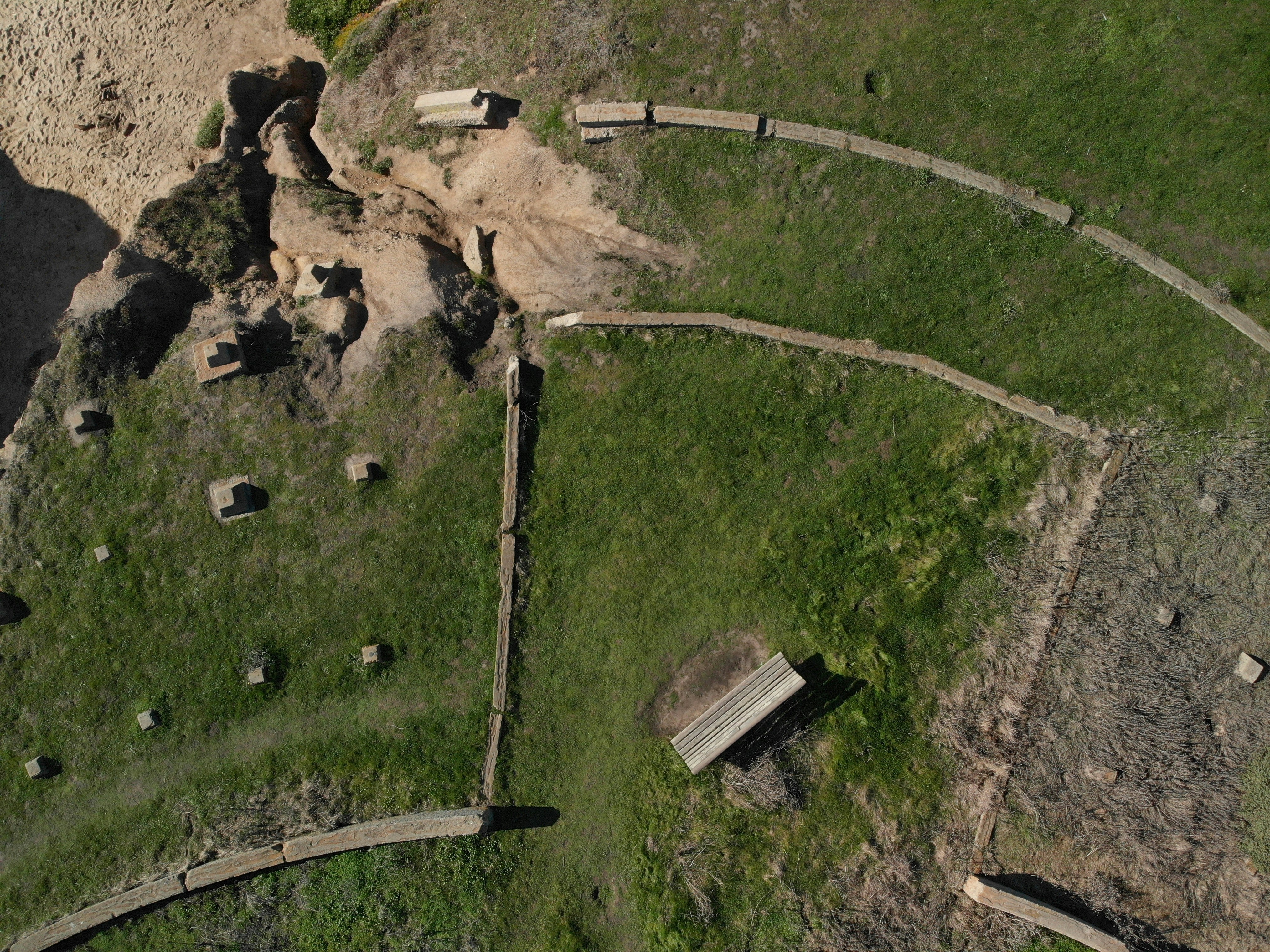 Ridge Ruins: A Drone View of Stonework Traced by Grass and Curved Paths