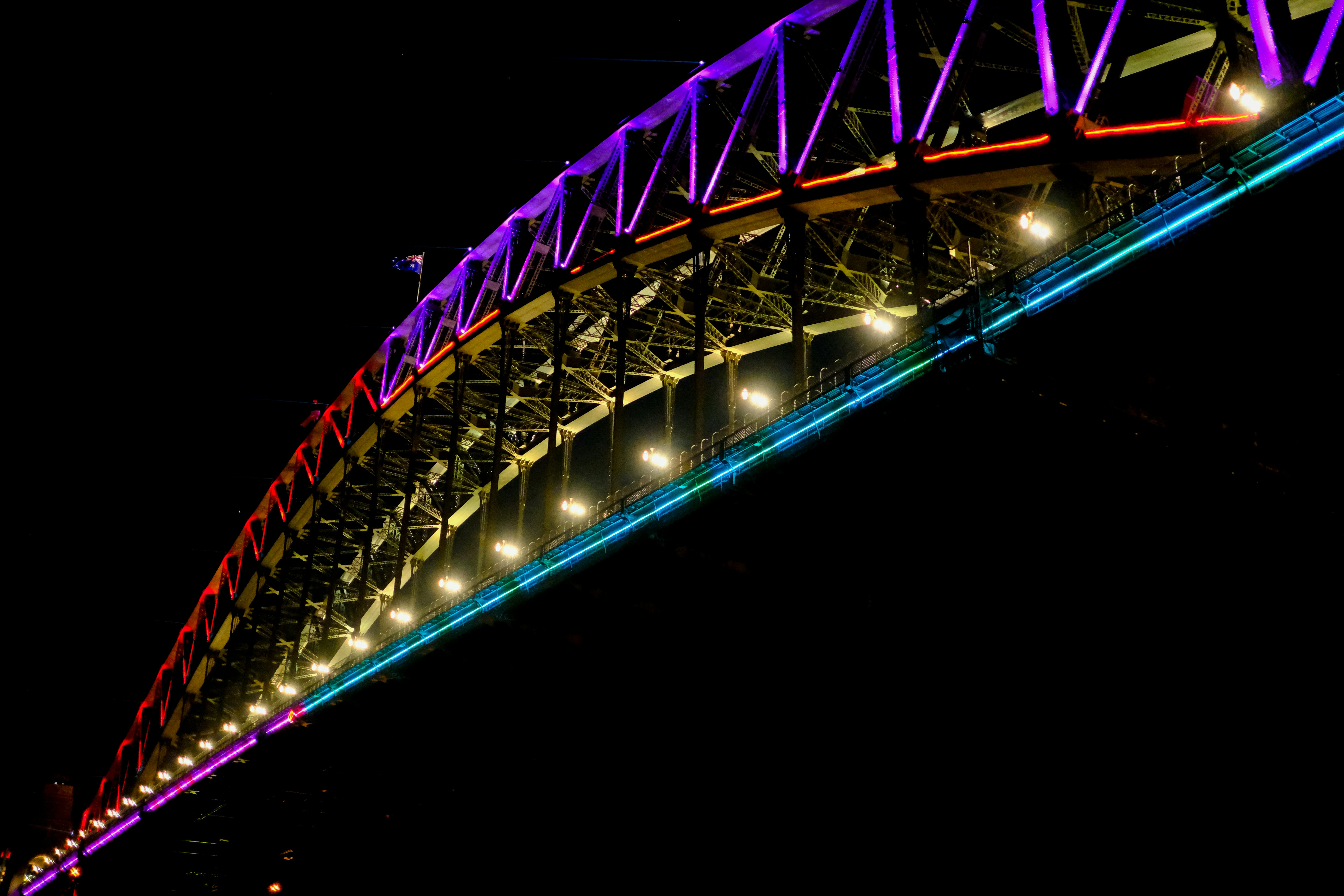 Neon Prism Over Night Water: Rainbow Arc of the City Bridge