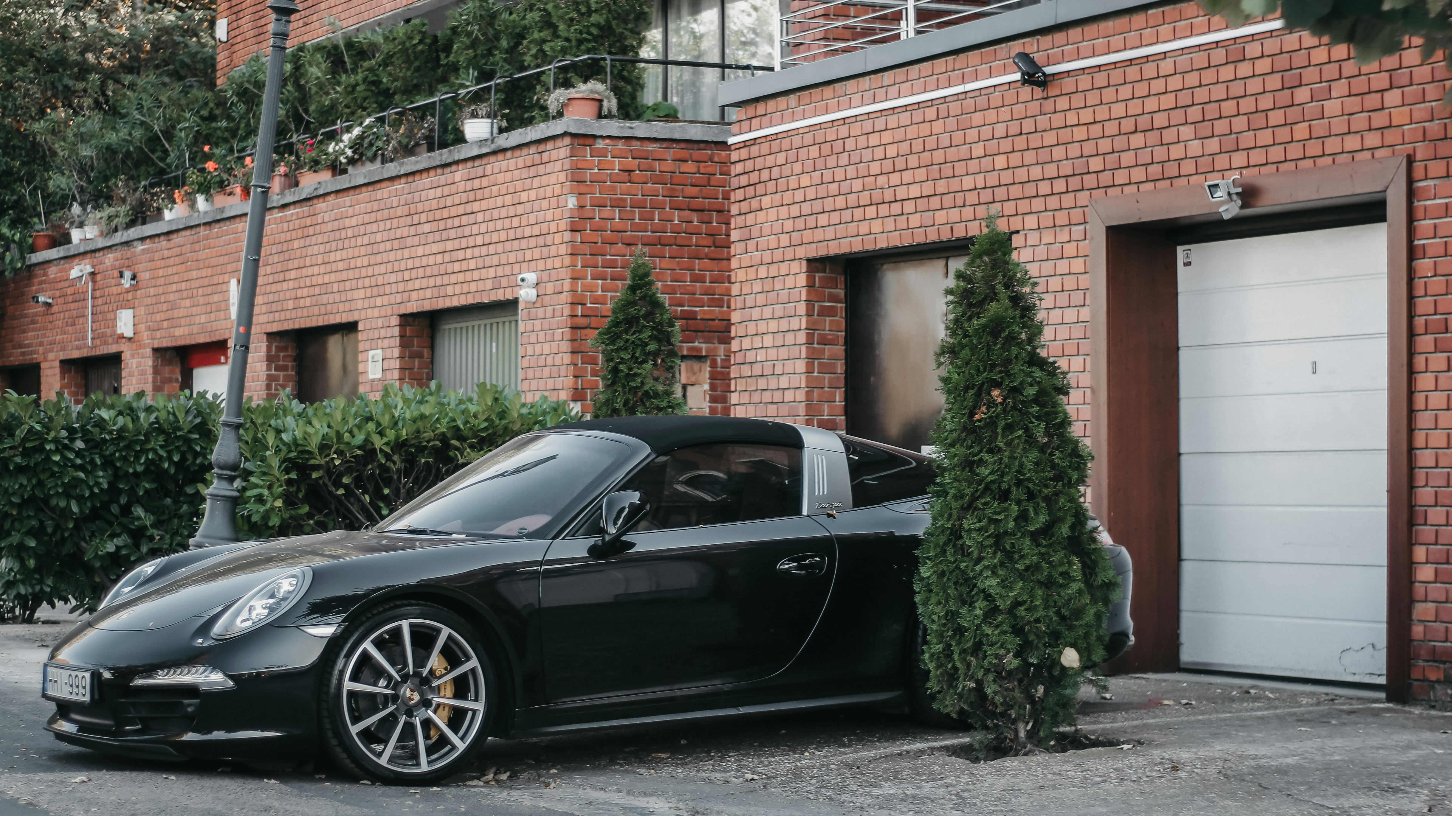 Midnight Porsche 911 Cabriolet by a brick townhouse driveway