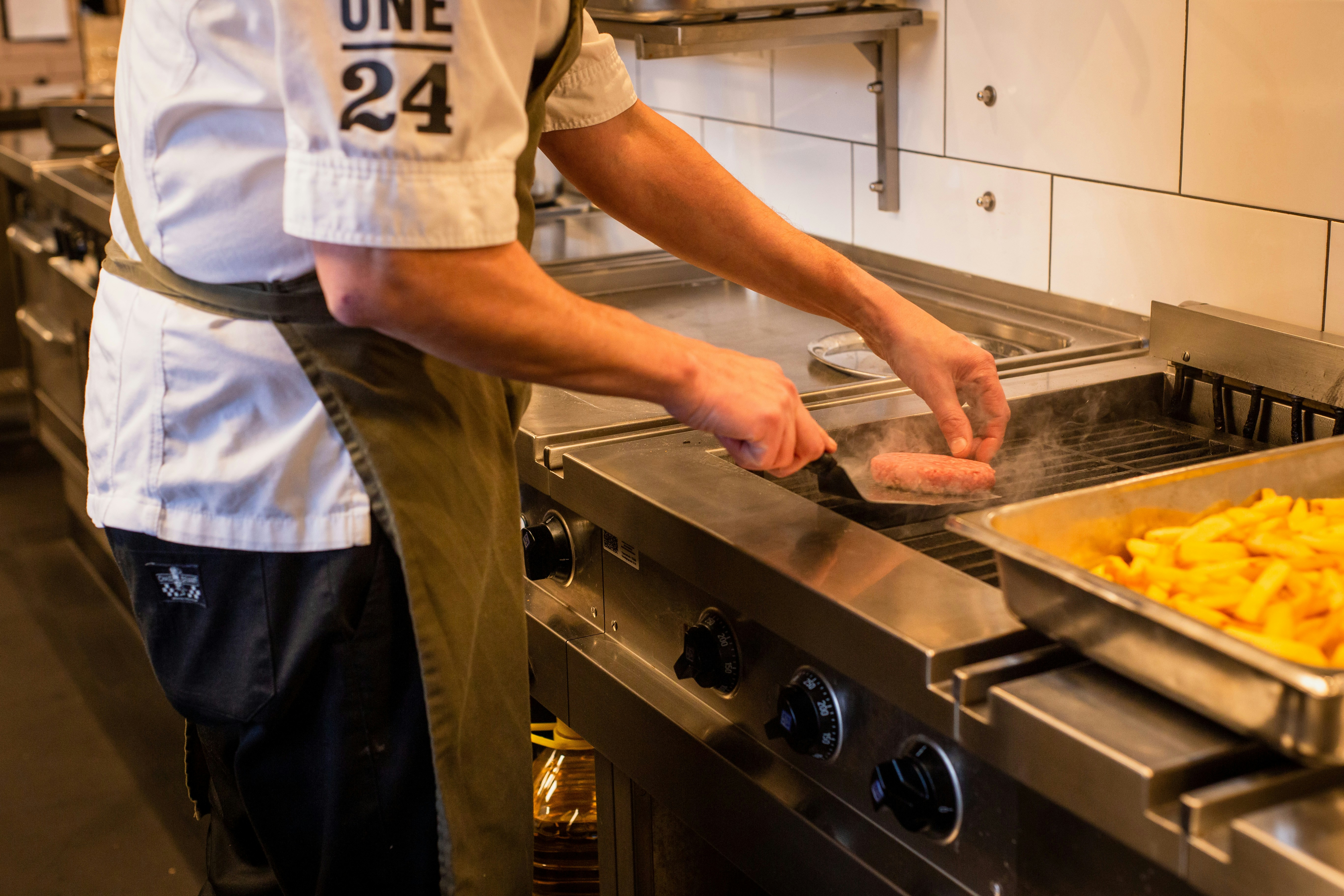 Sizzle and Focus: A Chef Vigilantly Turns Golden Potato Batons on a Commercial Range