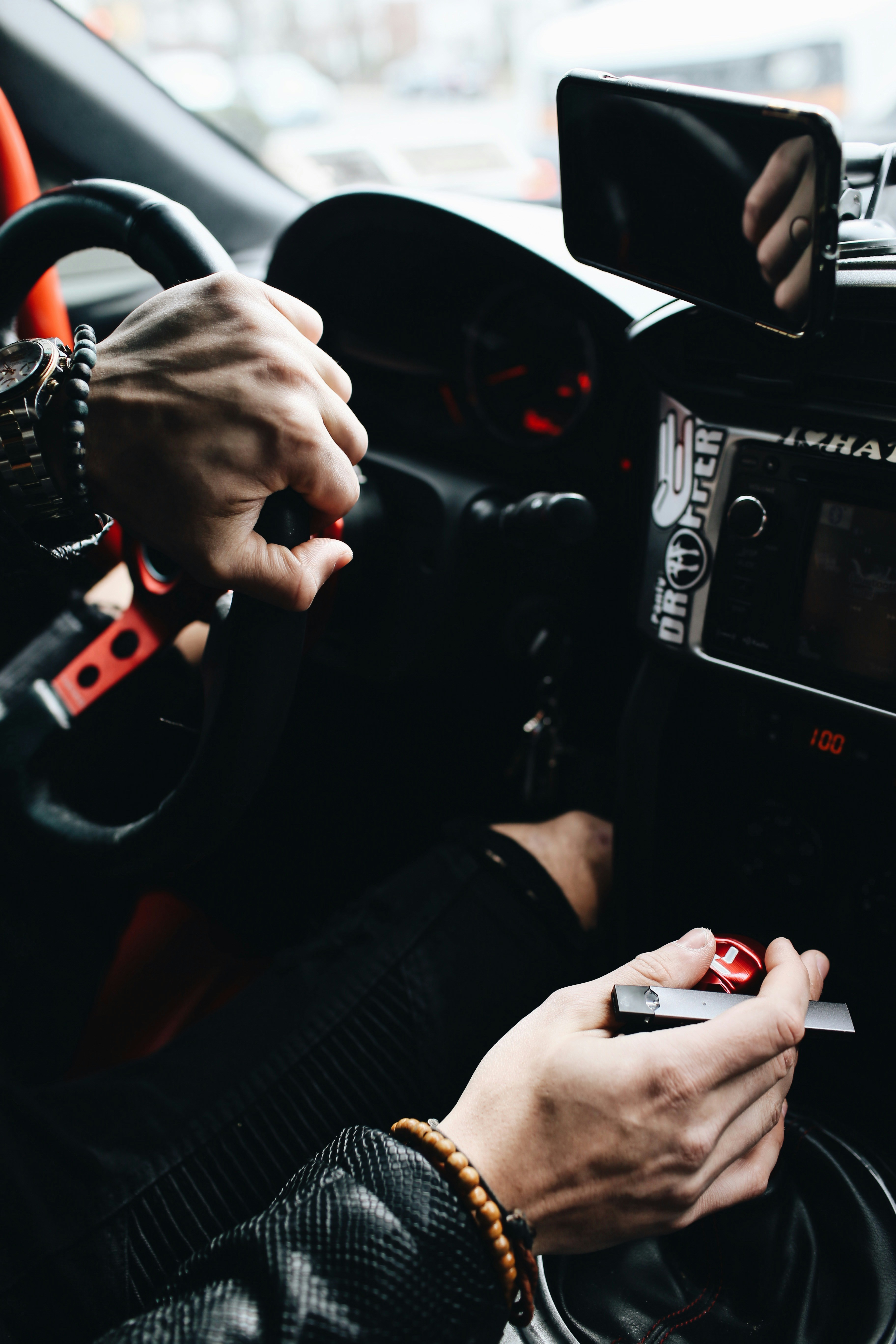 Grip and Glint: Close-Up of a Driver’s Hands at the Wheel with a Red Tool
