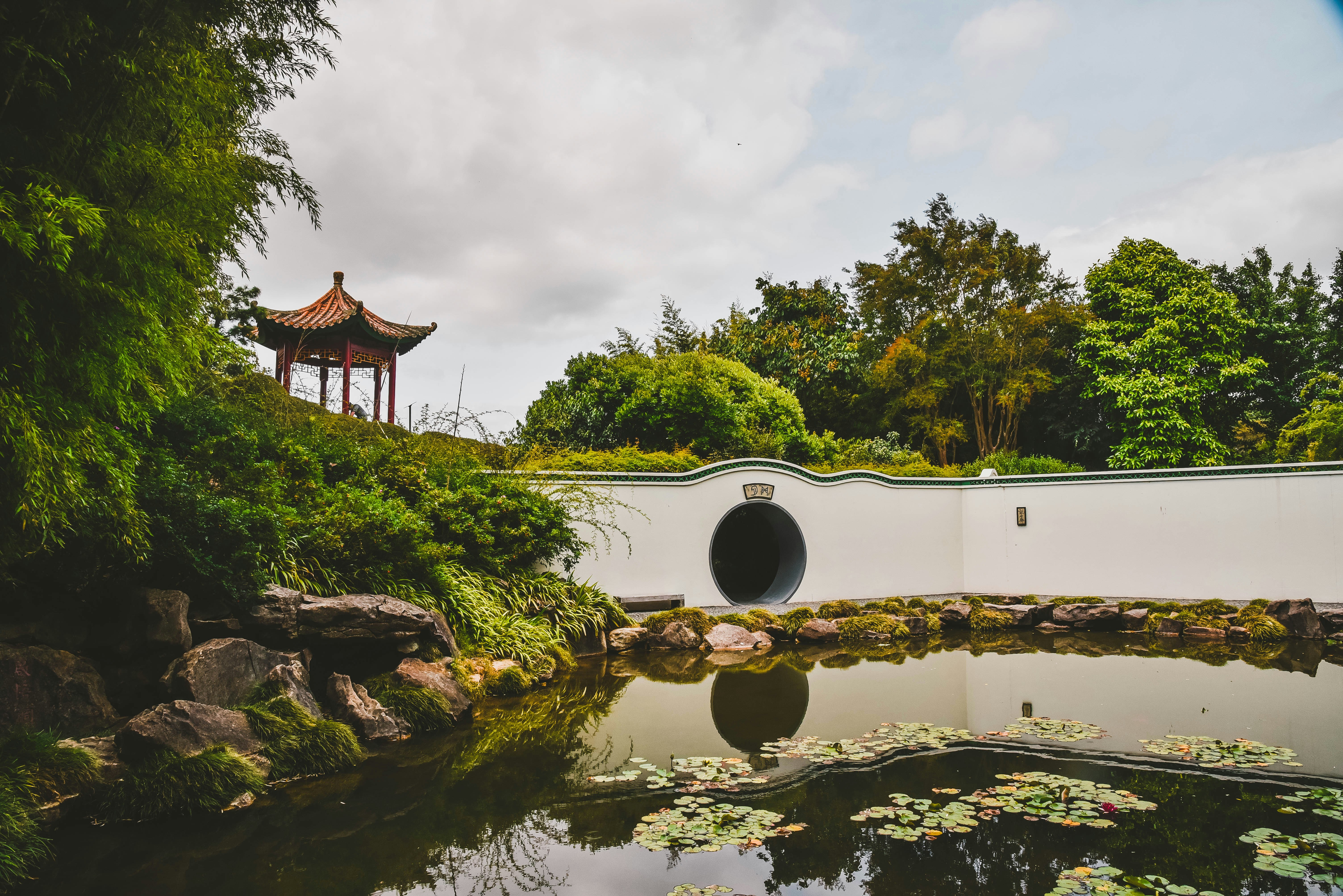 Serene Moon Gate: A Quiet Bridge Framed by Garden Stone and Lotus