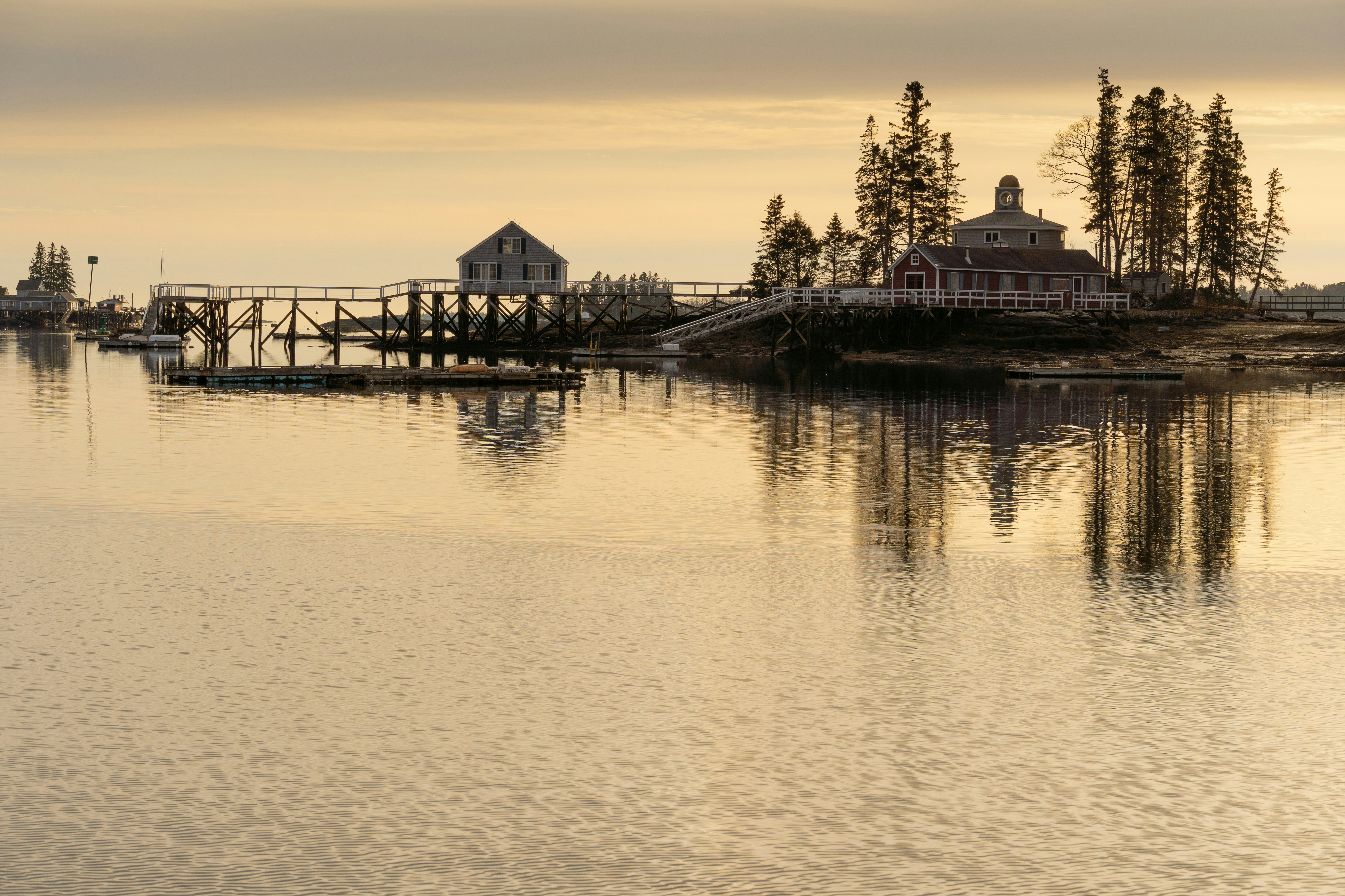 Dusk Harbor: Red-Roofed Retreat Beside a Timberside Pier