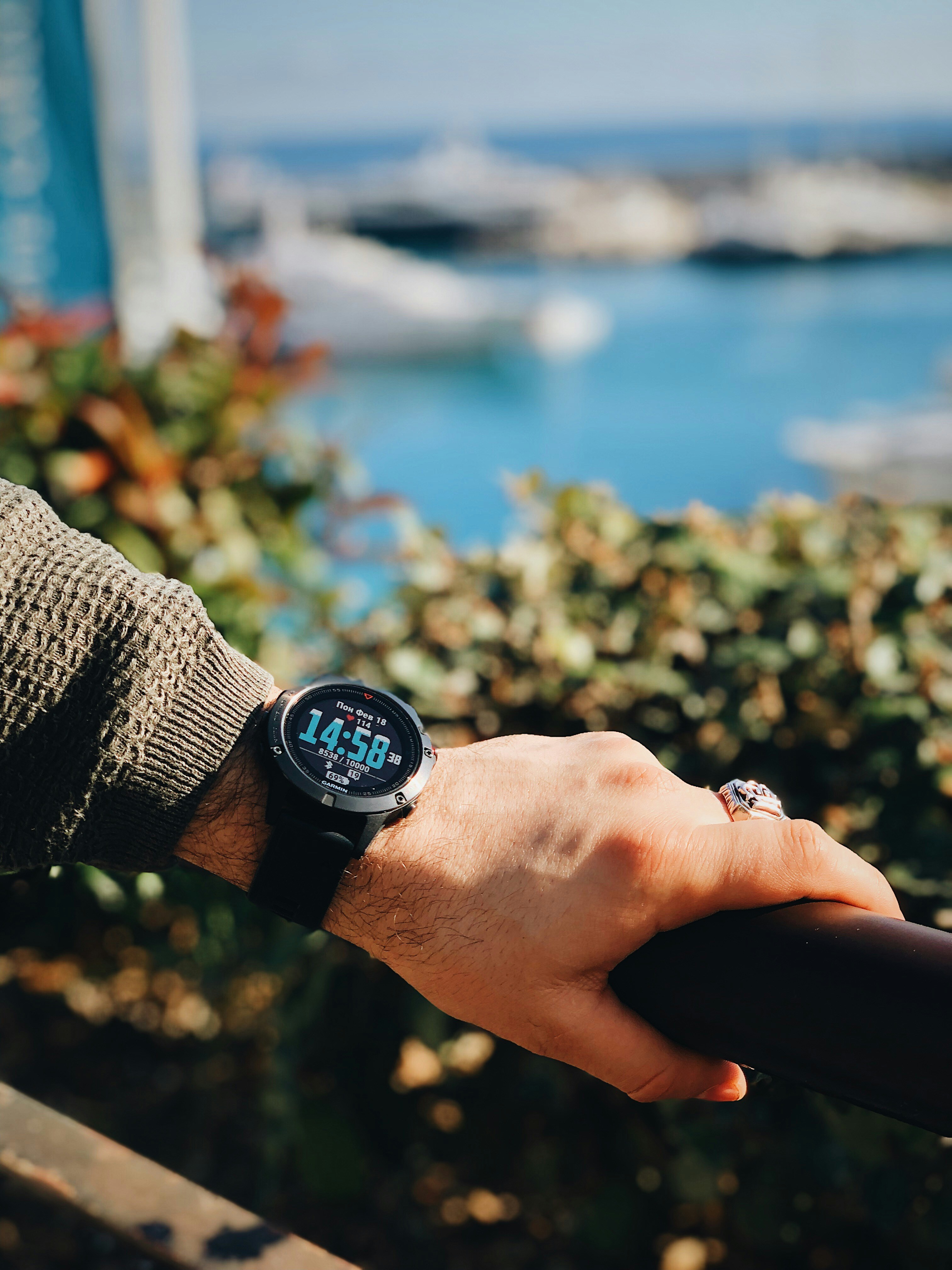 Close Up of a Wristwatch in the Foreground with a Sea Harbor Background