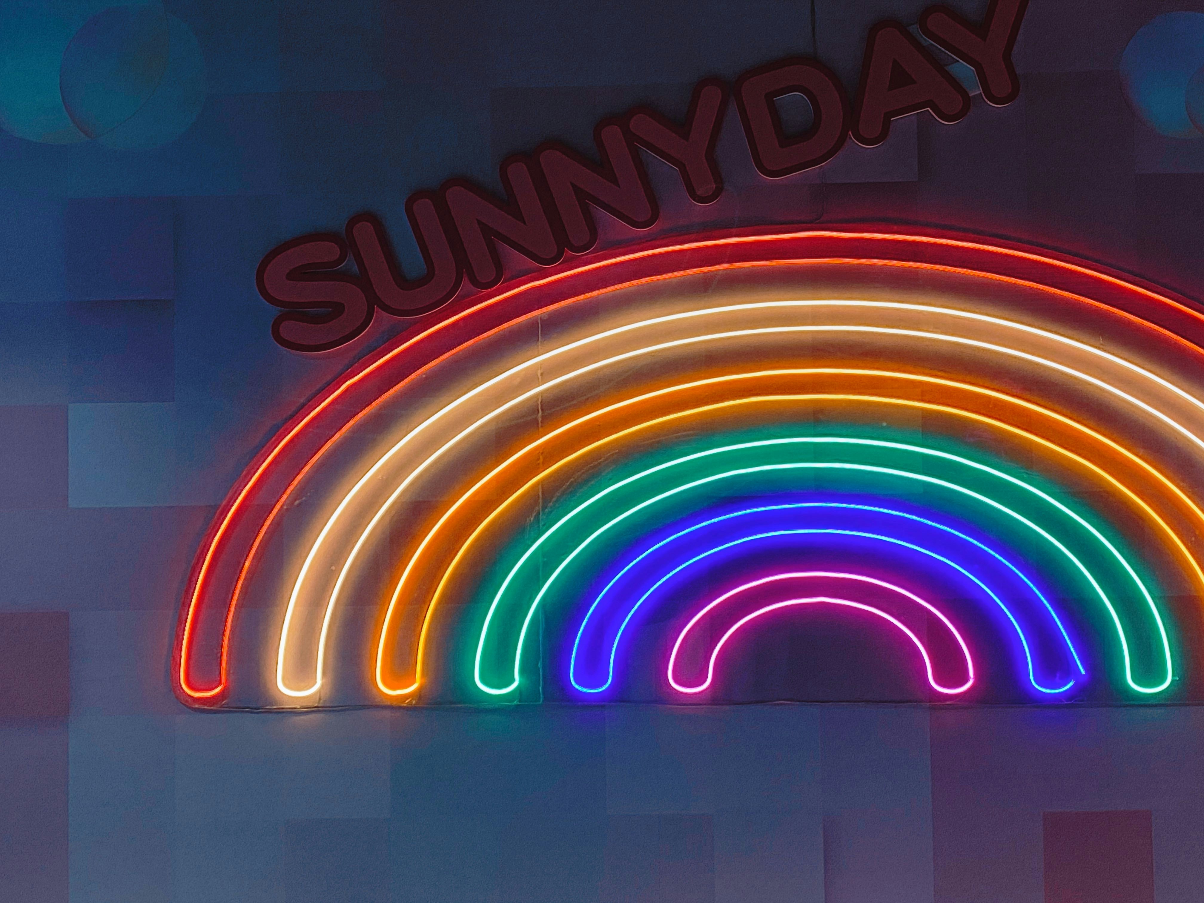 Sunnyday Neon Rainbow Arch Over a Nighttime Sign