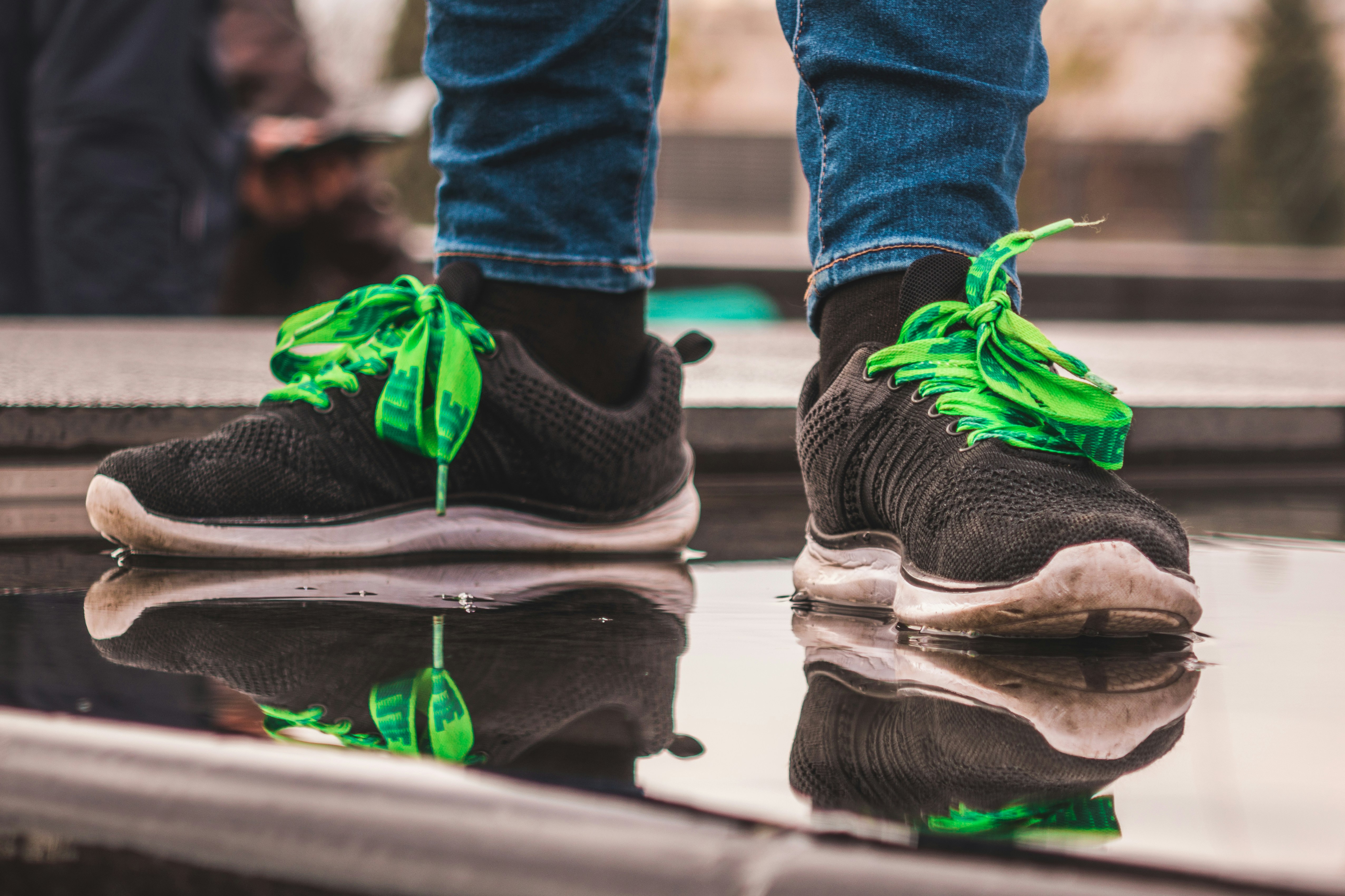 Green-Laced Steps: Reflective Shoes on a Wet Stage