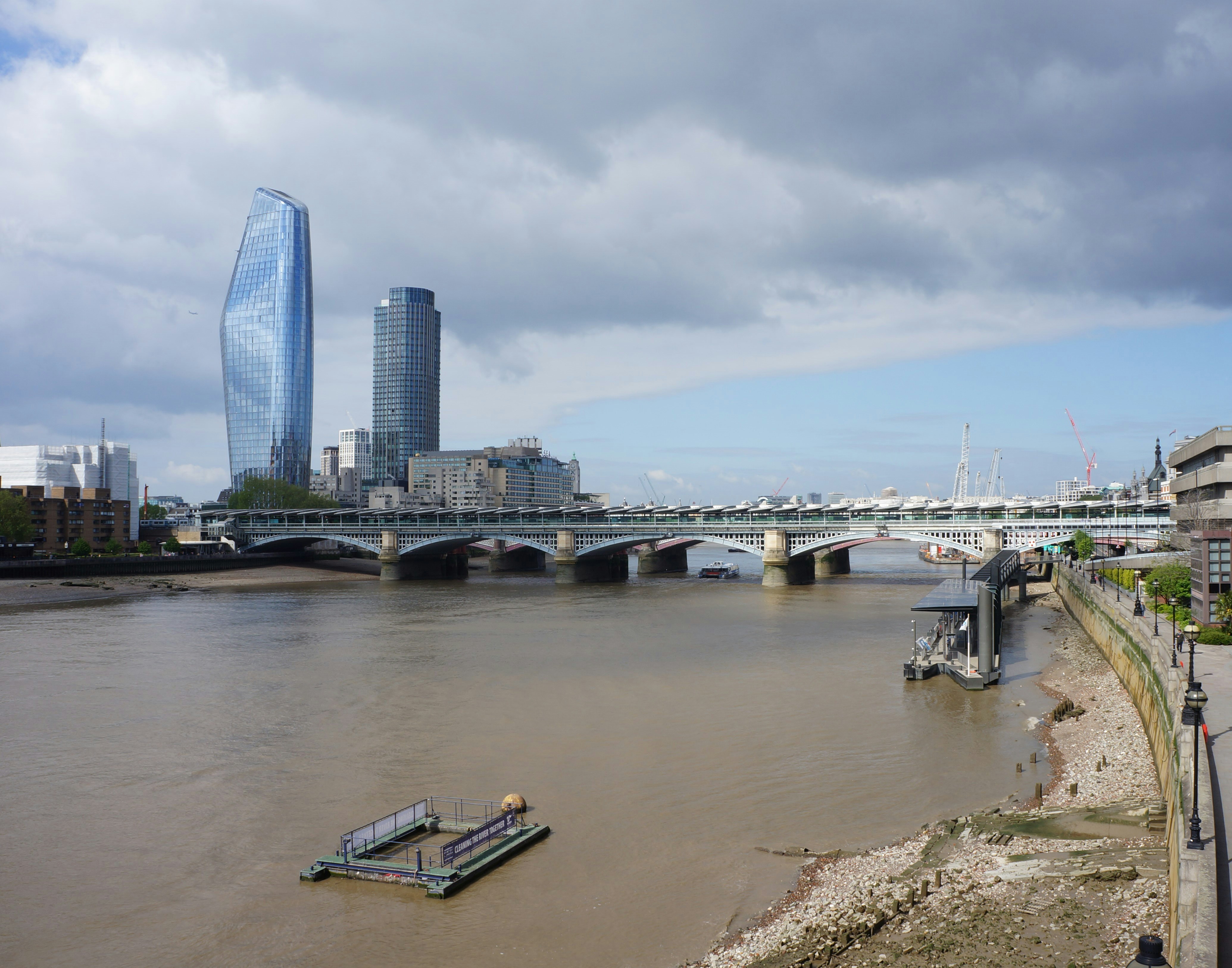 A boat floating on top of a river next to a bridge photo – Free Boat ...