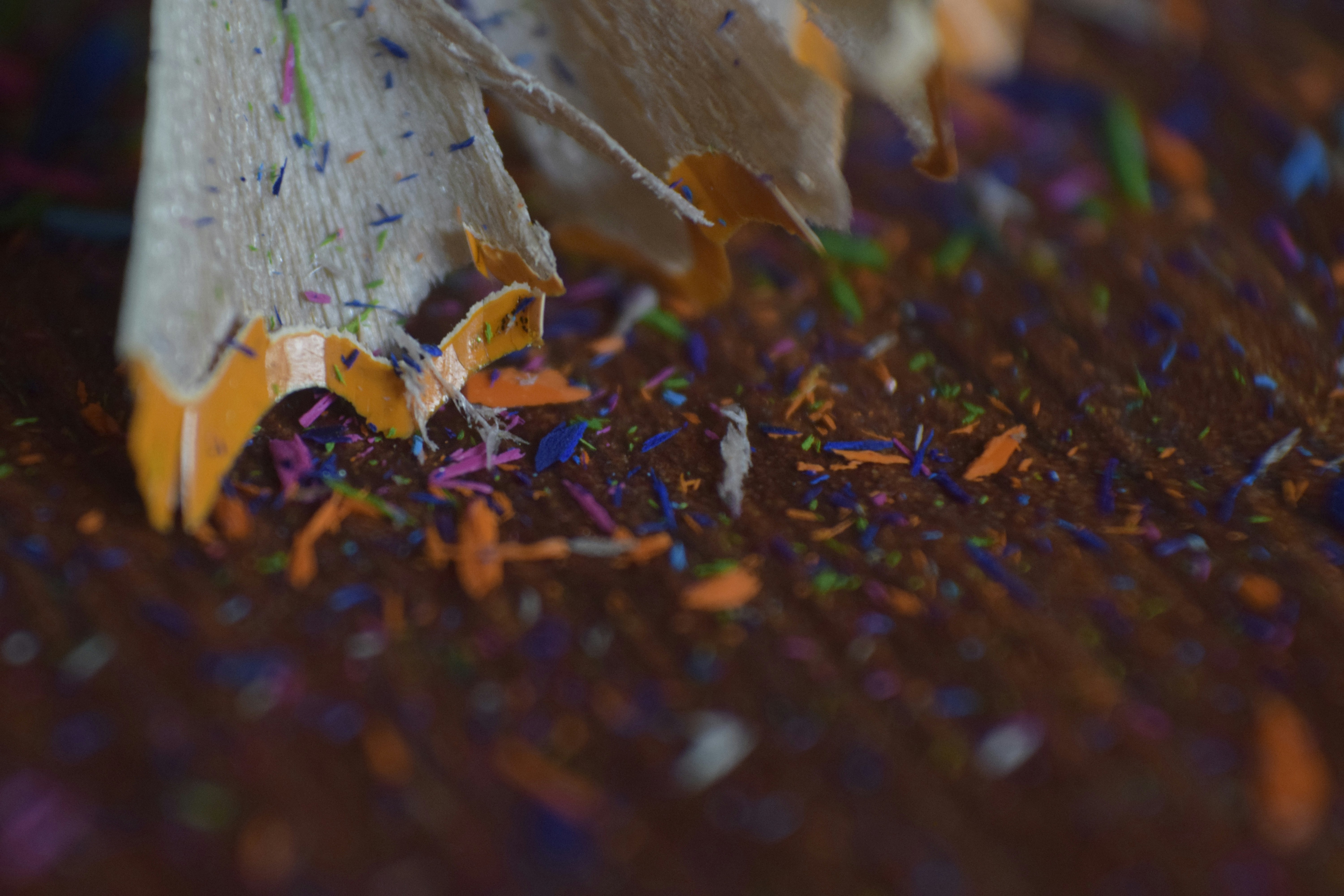 Edge of Color: A Macro Study of Pencil Shavings on a Confetti-Strewn Surface