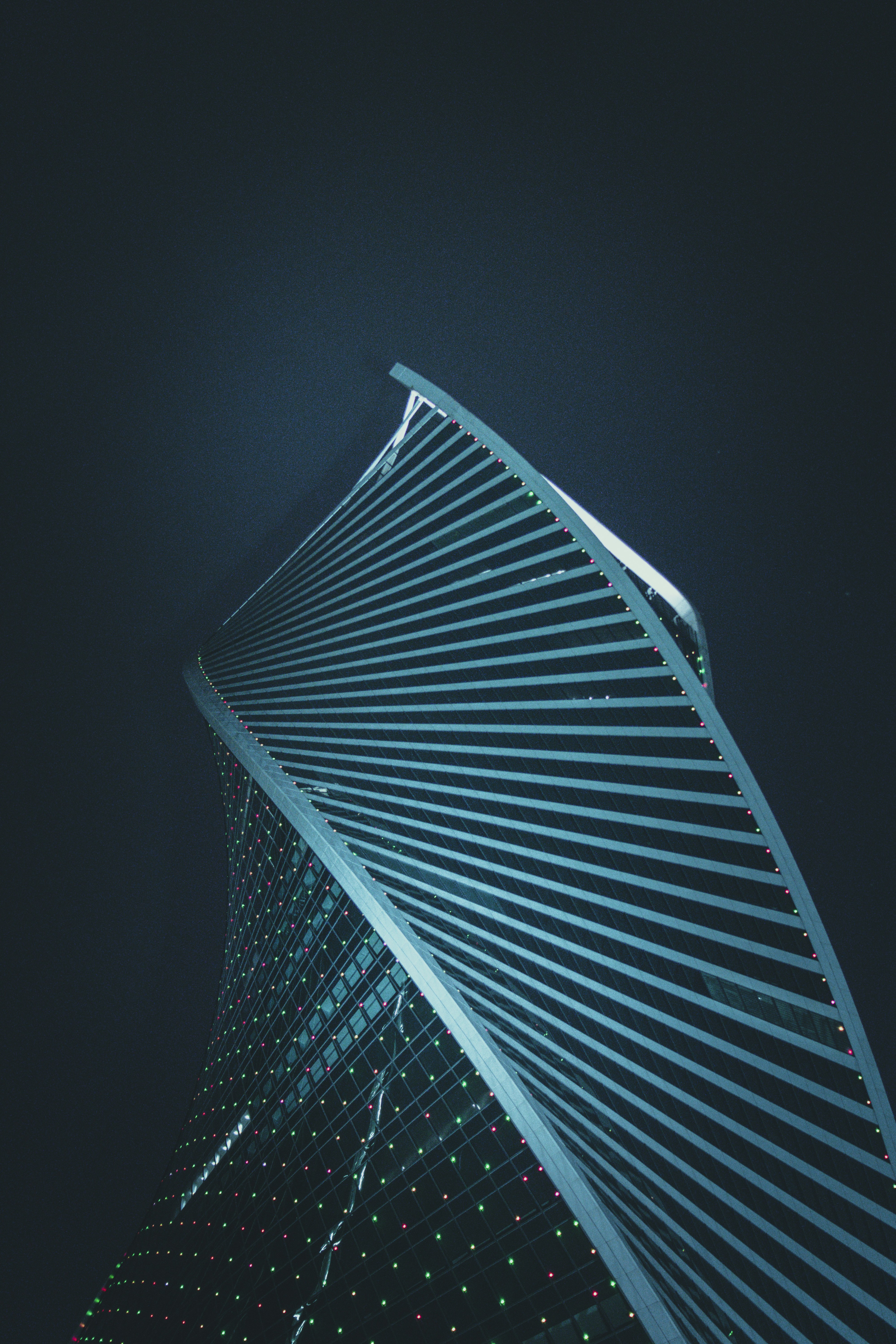 Abstract architectural structure illuminated with colorful lights against a dark backdrop.