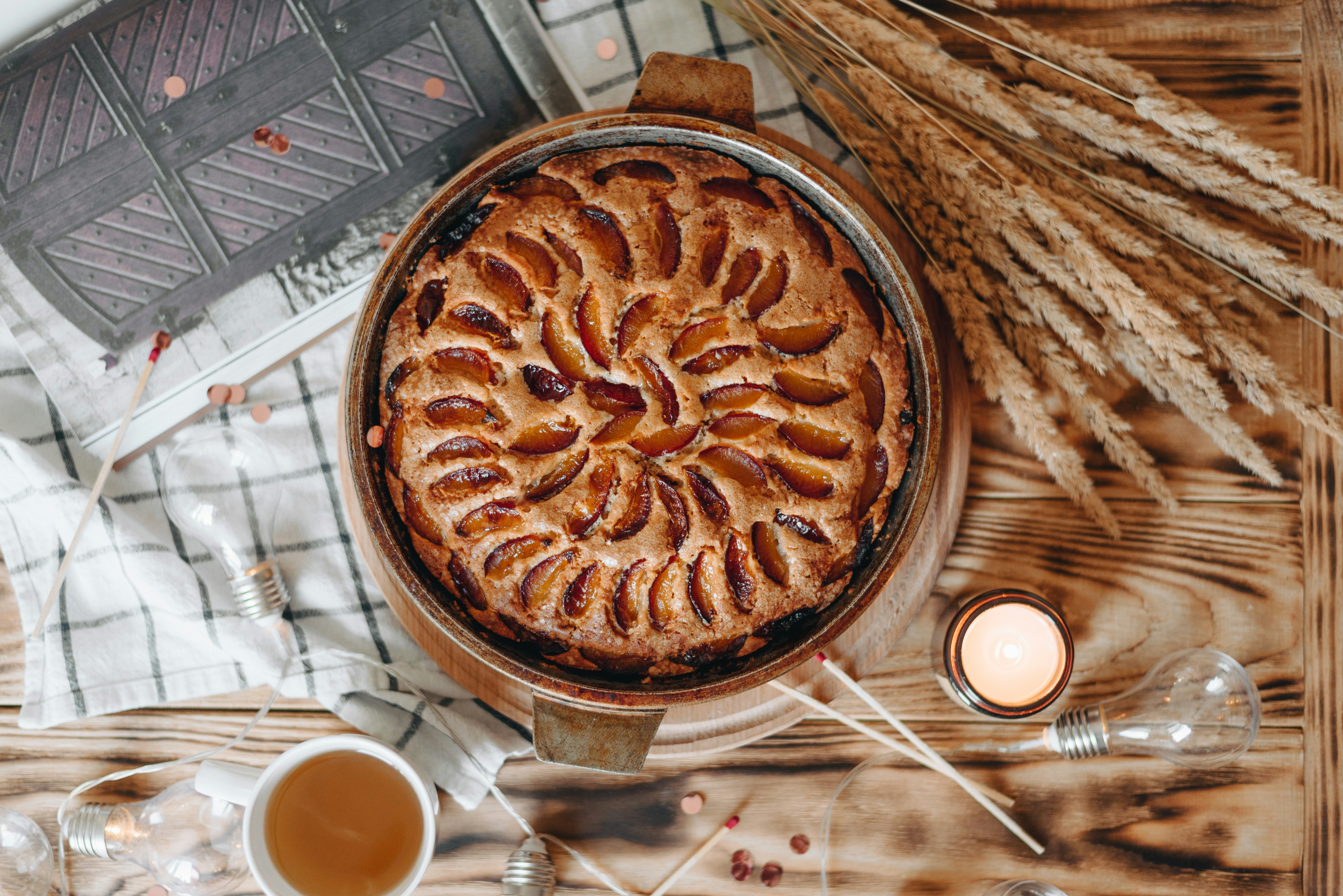 Baked cake near brown wheat, clear light bulb, and tea in white ceramic ...
