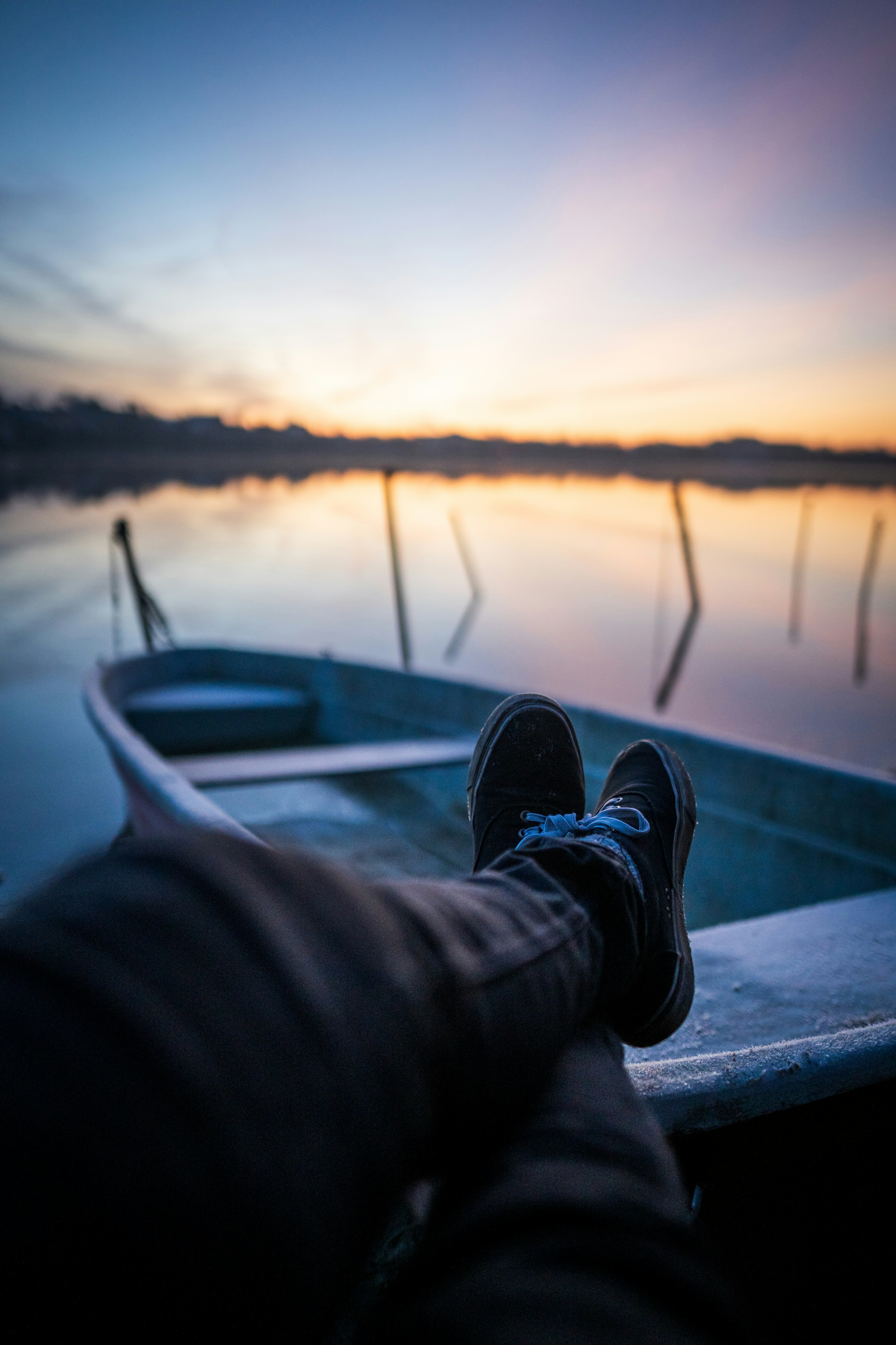 Boots at the Bow: Sunset Reverie on a Calm Lake