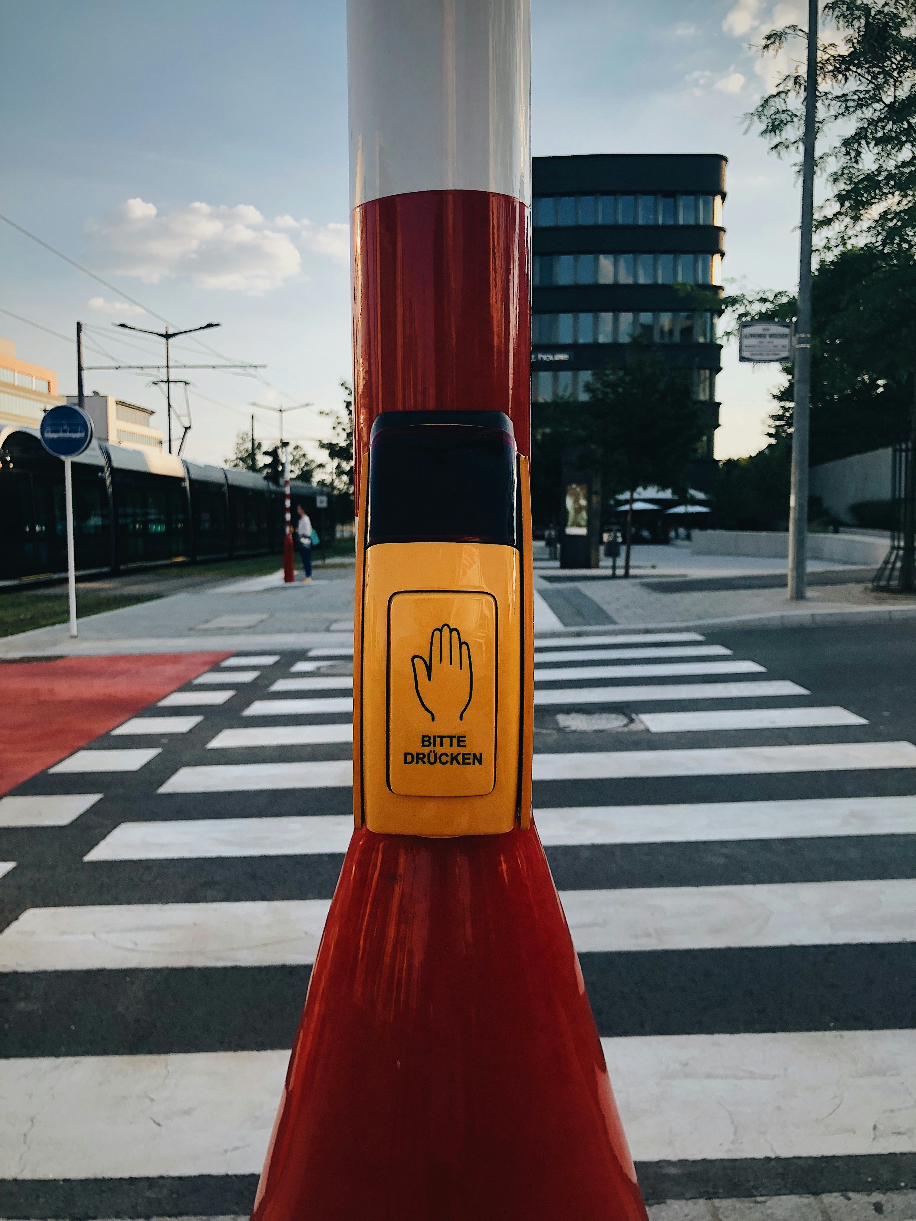 Crosswalk Pulse: A Pulsing Yellow Button on a Red Street Column
