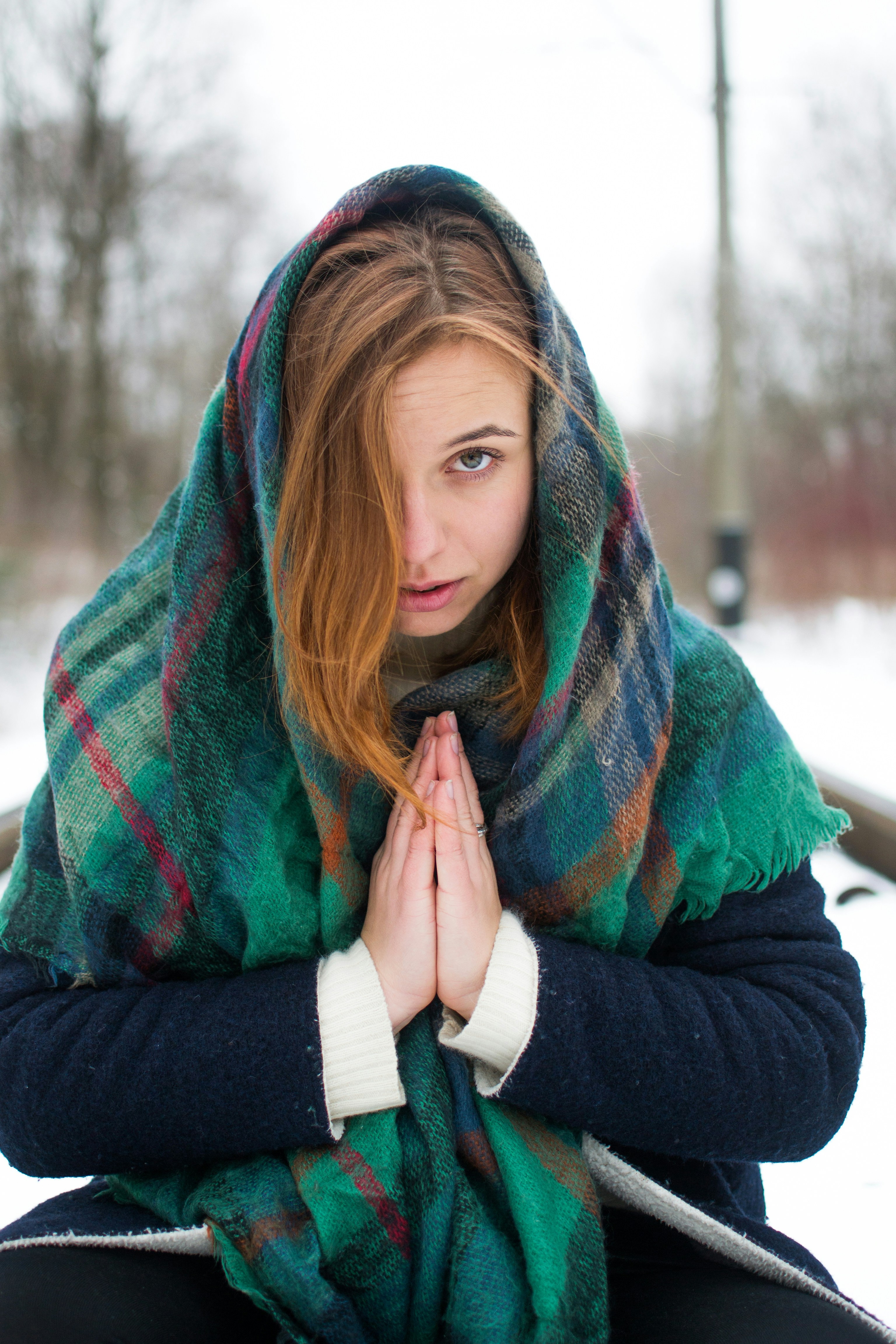 Winter Quiet: Hands in Prayer beneath a Plaid Woolen Wrap