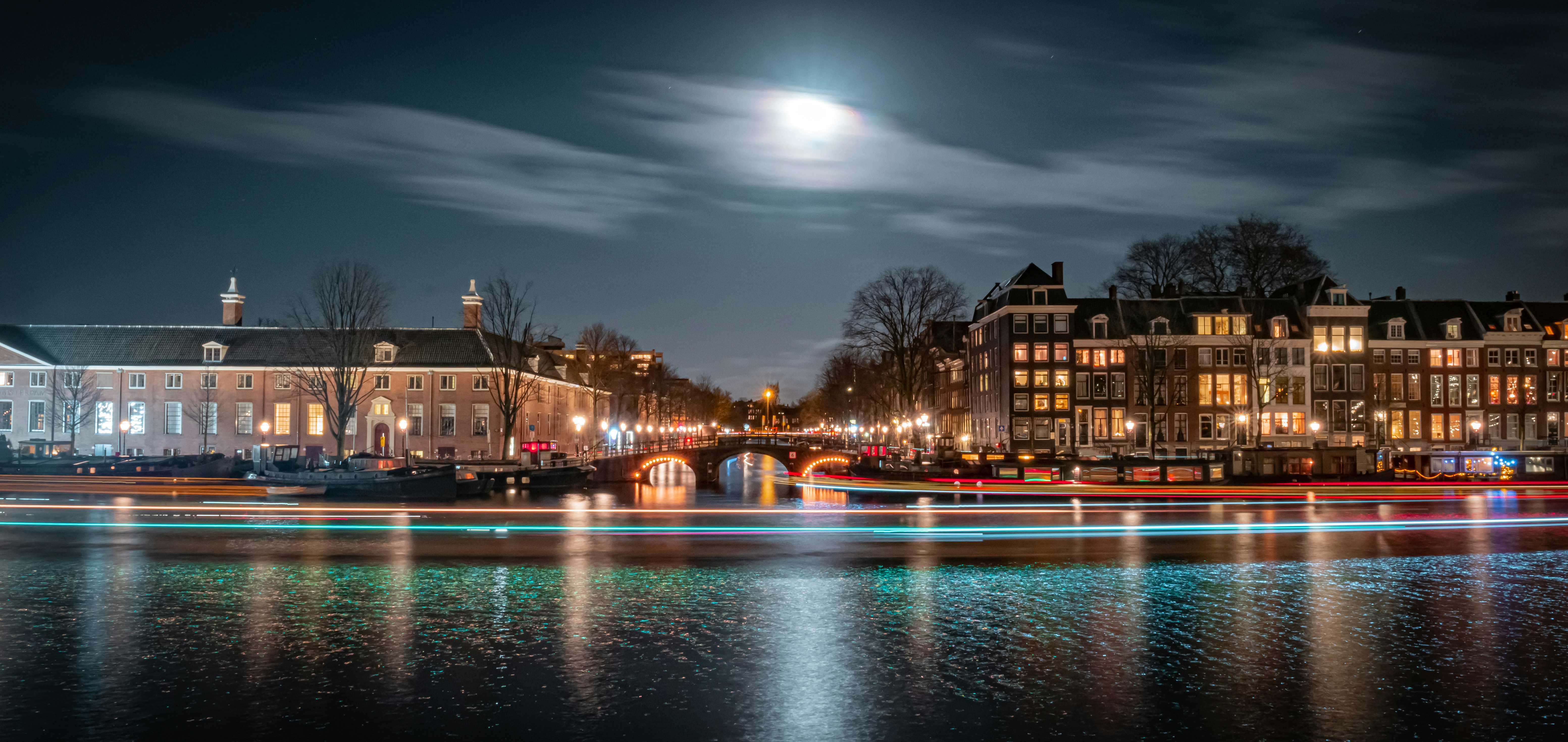 Moonlit Canal Lights: A Night Ride Under the Bridge