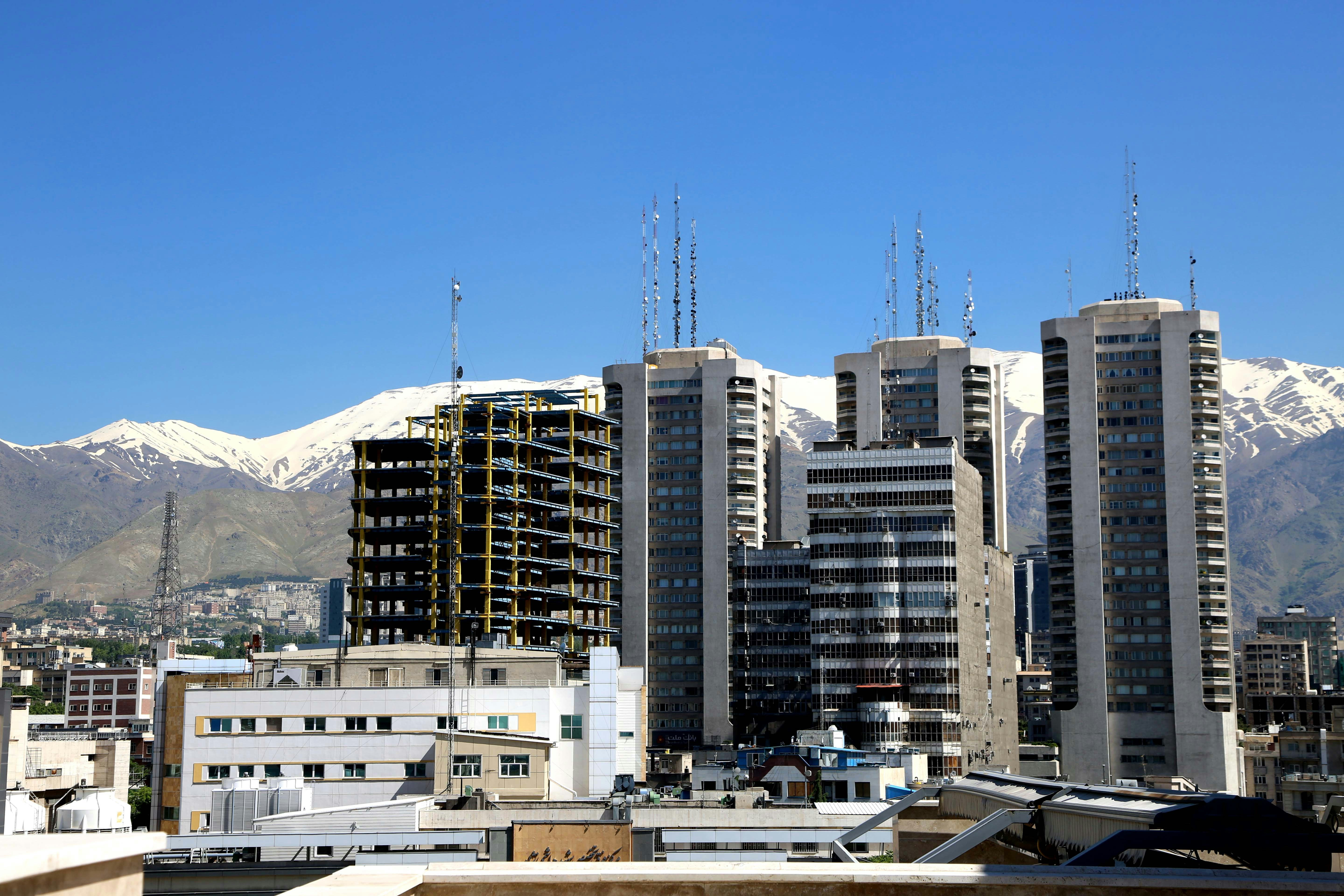 City with high-rise buildings viewing mountain under blue sky photo ...