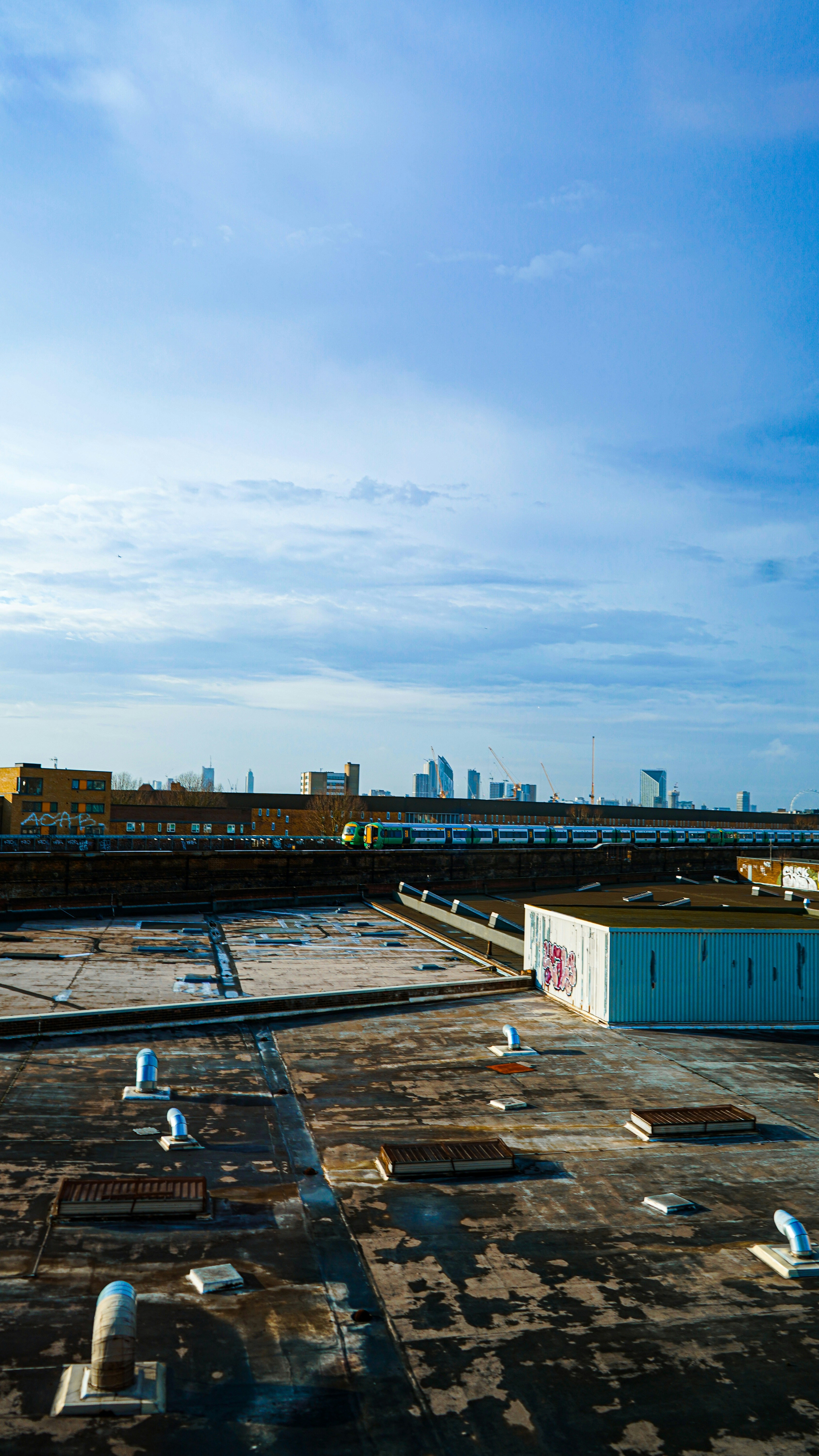 A Rooftop in London overlooking the city while a Tube train flies past.