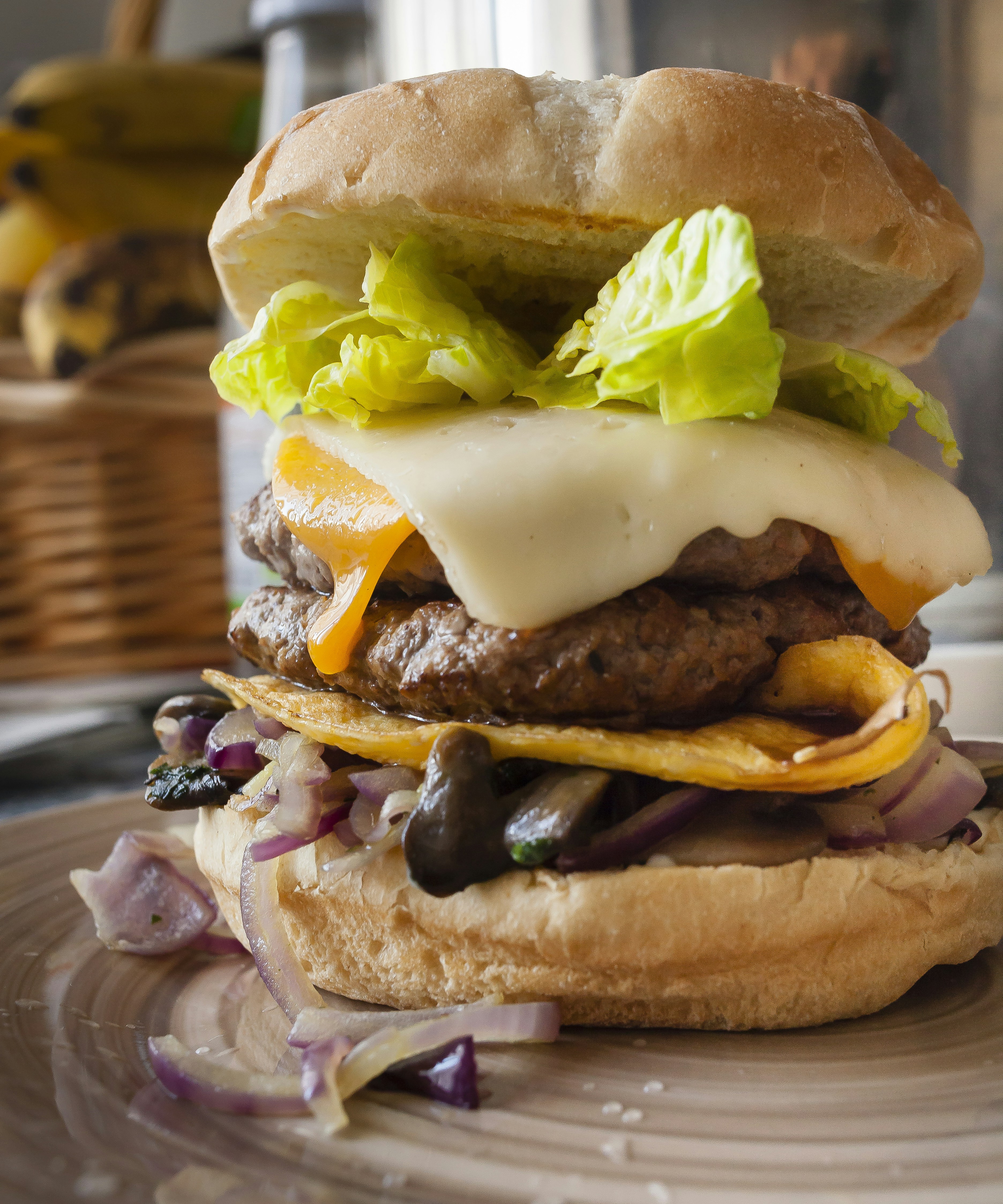 Stacked Burger Symphony: Melted Cheese Cloaks a Juicy Patty Beneath Crisp Veg