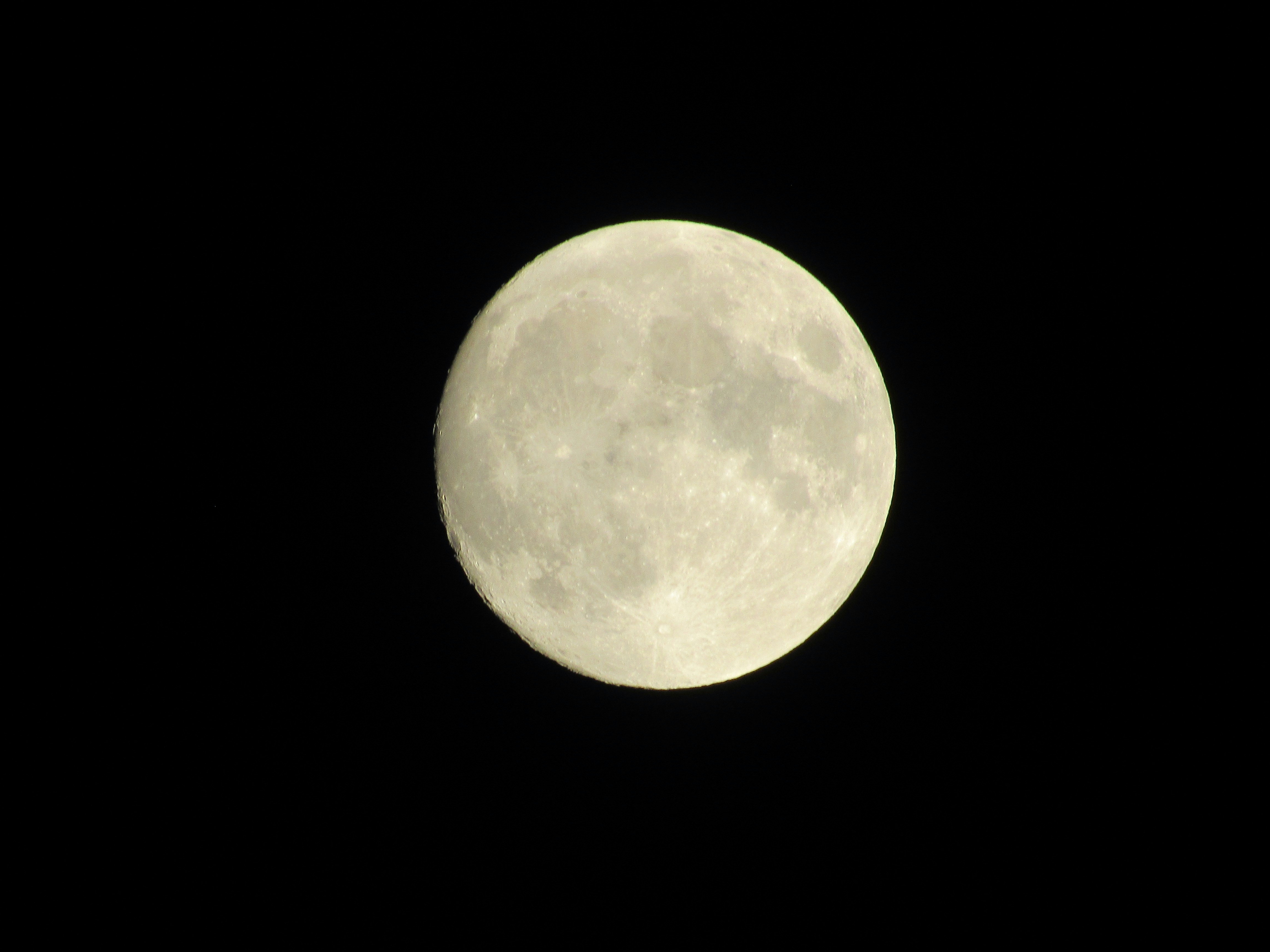 Full moon against a dark night sky, showcasing surface details and craters.