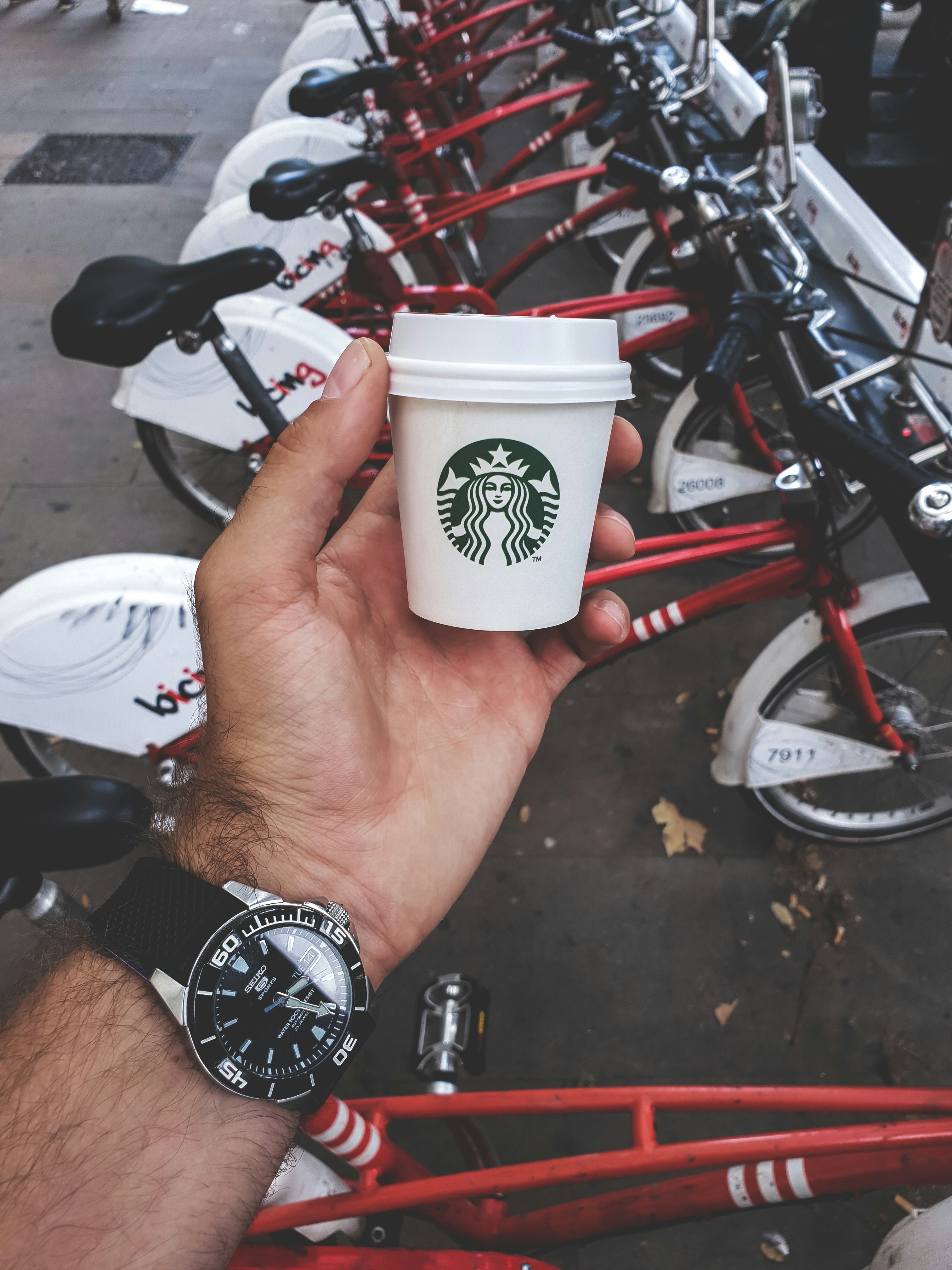 Coffee Cup Spotlight: Hand, Watch, and Bikes in Red