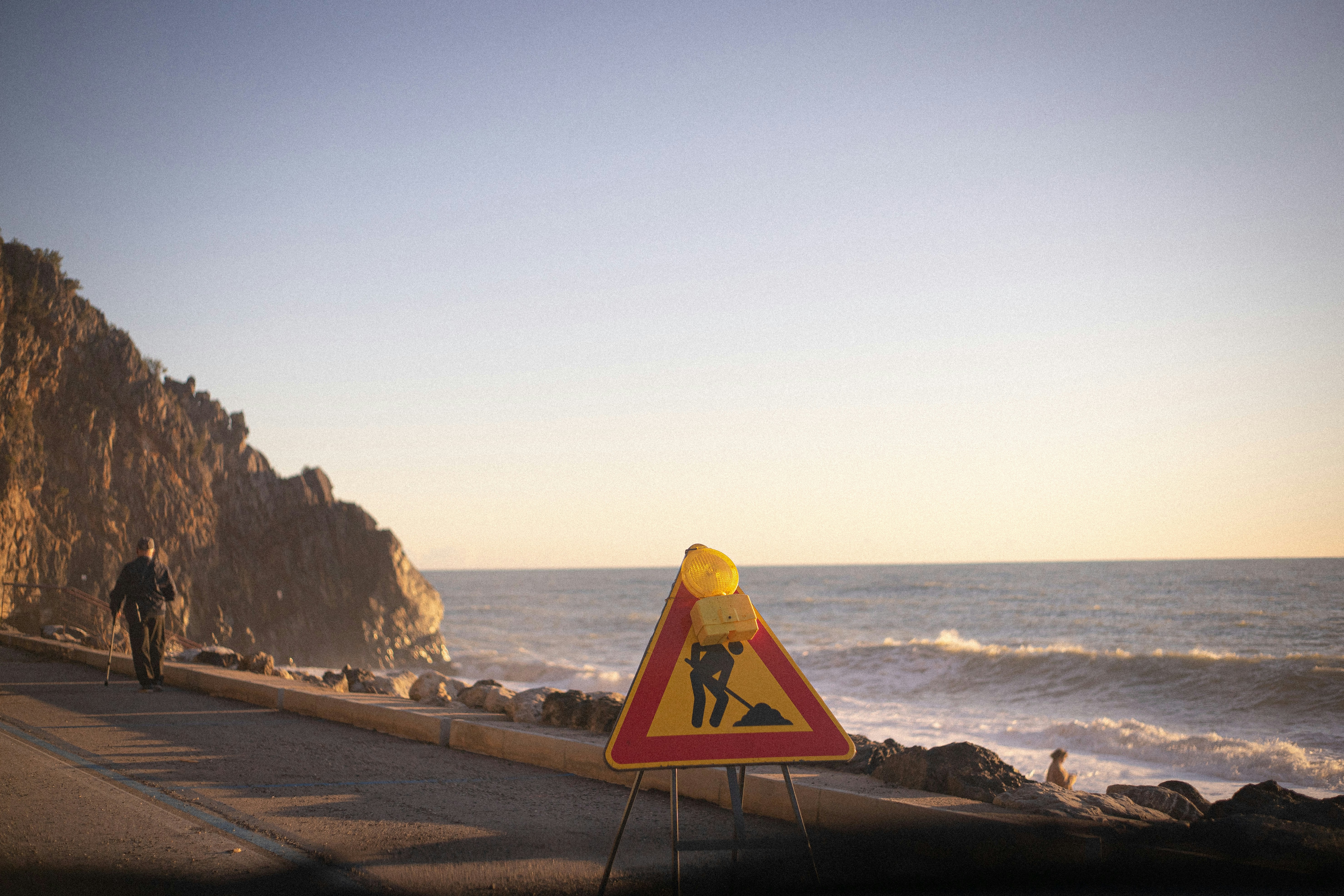 Triangle of Caution at Golden Hour by a Quiet Seaside Promenade