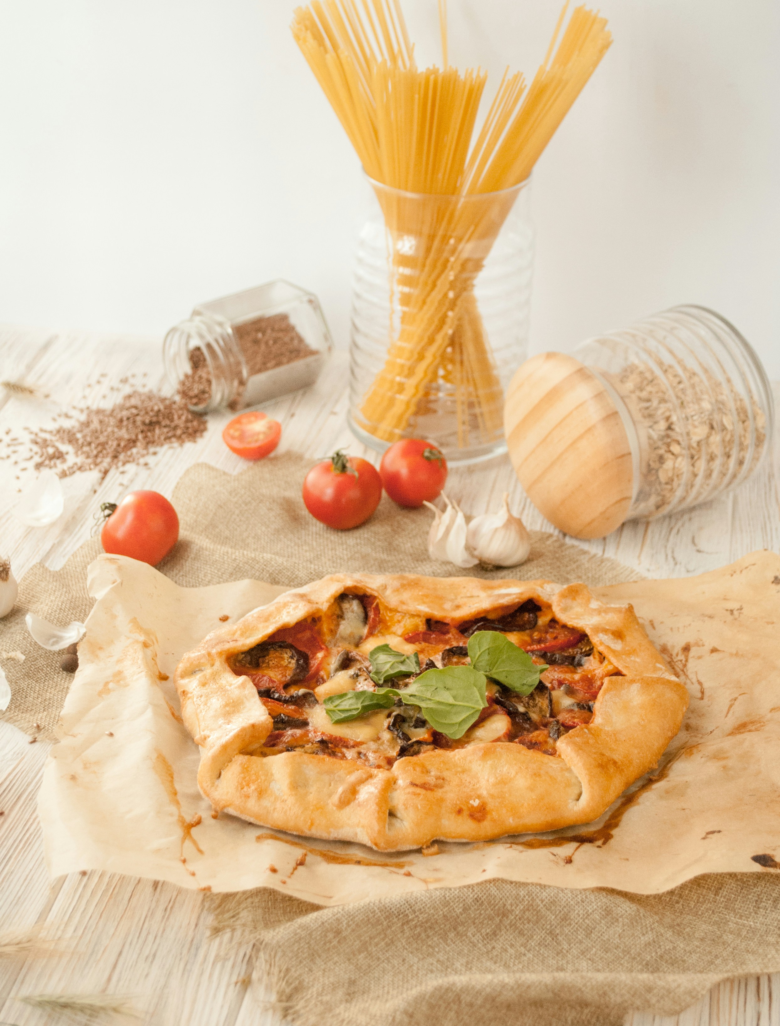 Baked pizza beside tomatoes and garlic photo – Free Brown Image on Unsplash