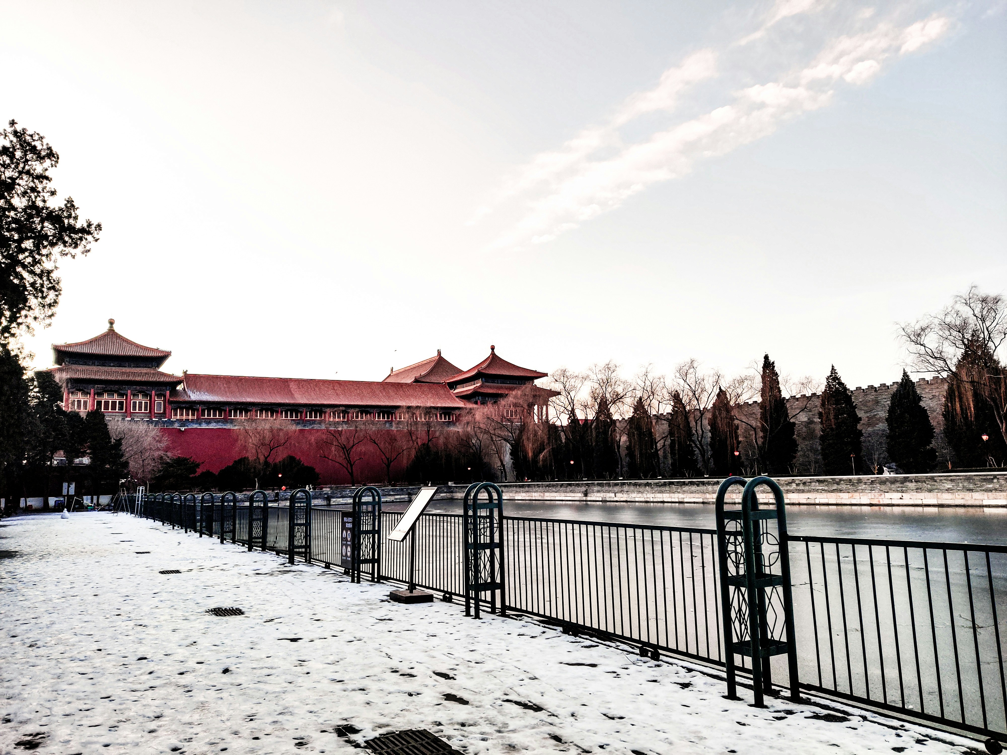 Snow-Dusted Reds: Quiet Edge of a Lake with a Red-Walled Temple