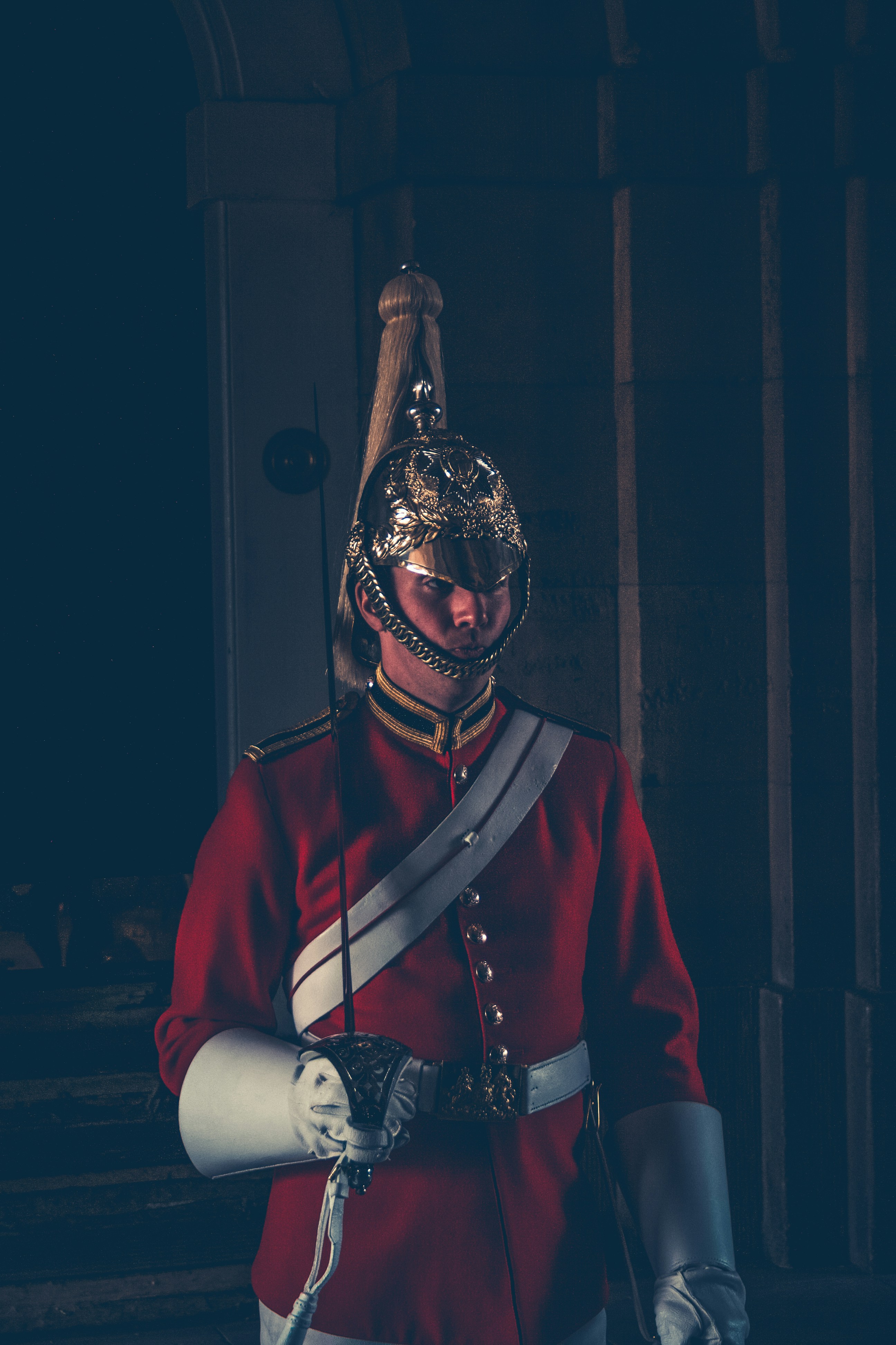 Crimson Sentinel in a Dim Hall: Ceremonial Guard with Ornate Crest