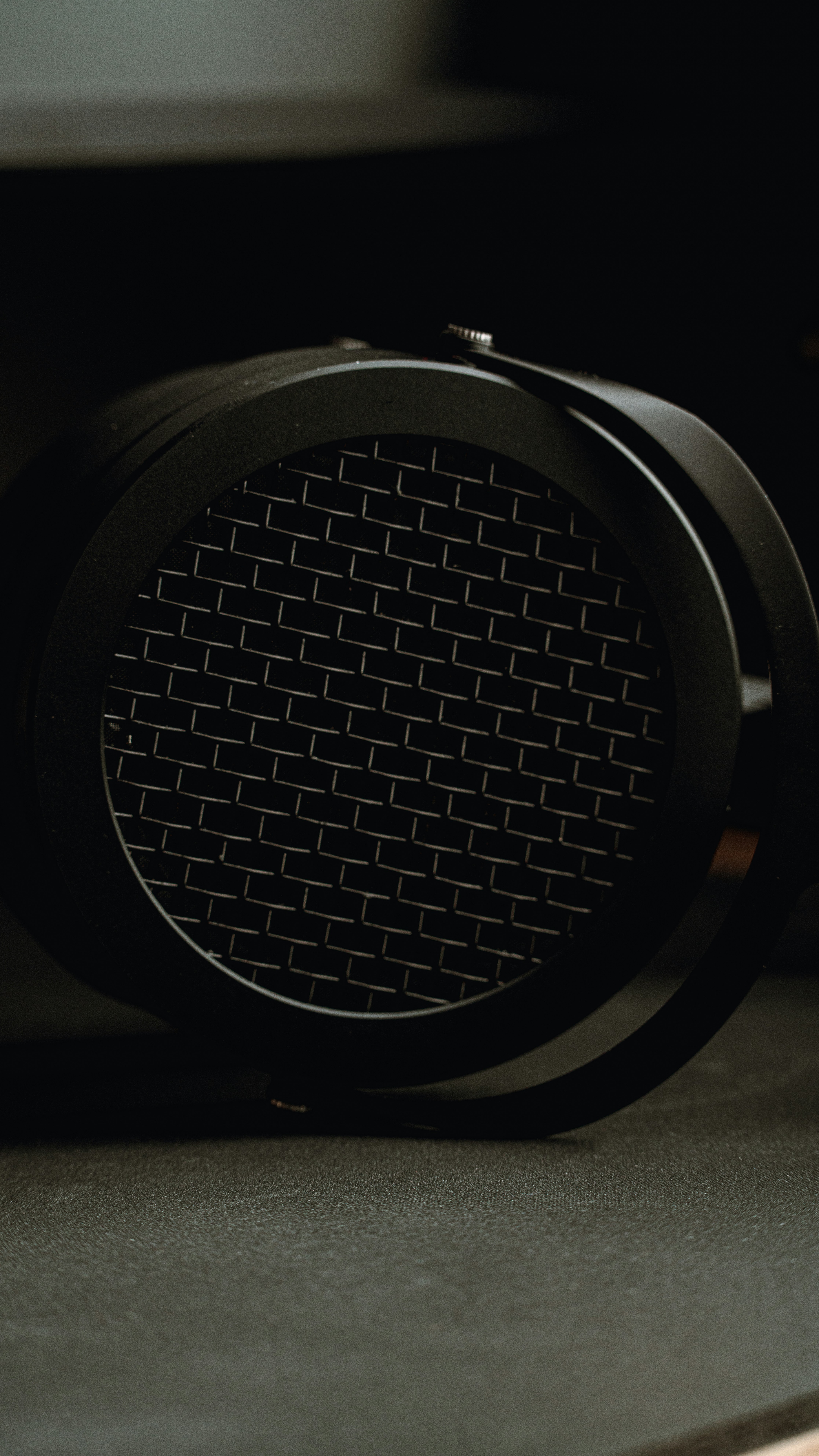Close-up of a high-fidelity headphone grill showcasing intricate mesh design and craftsmanship.