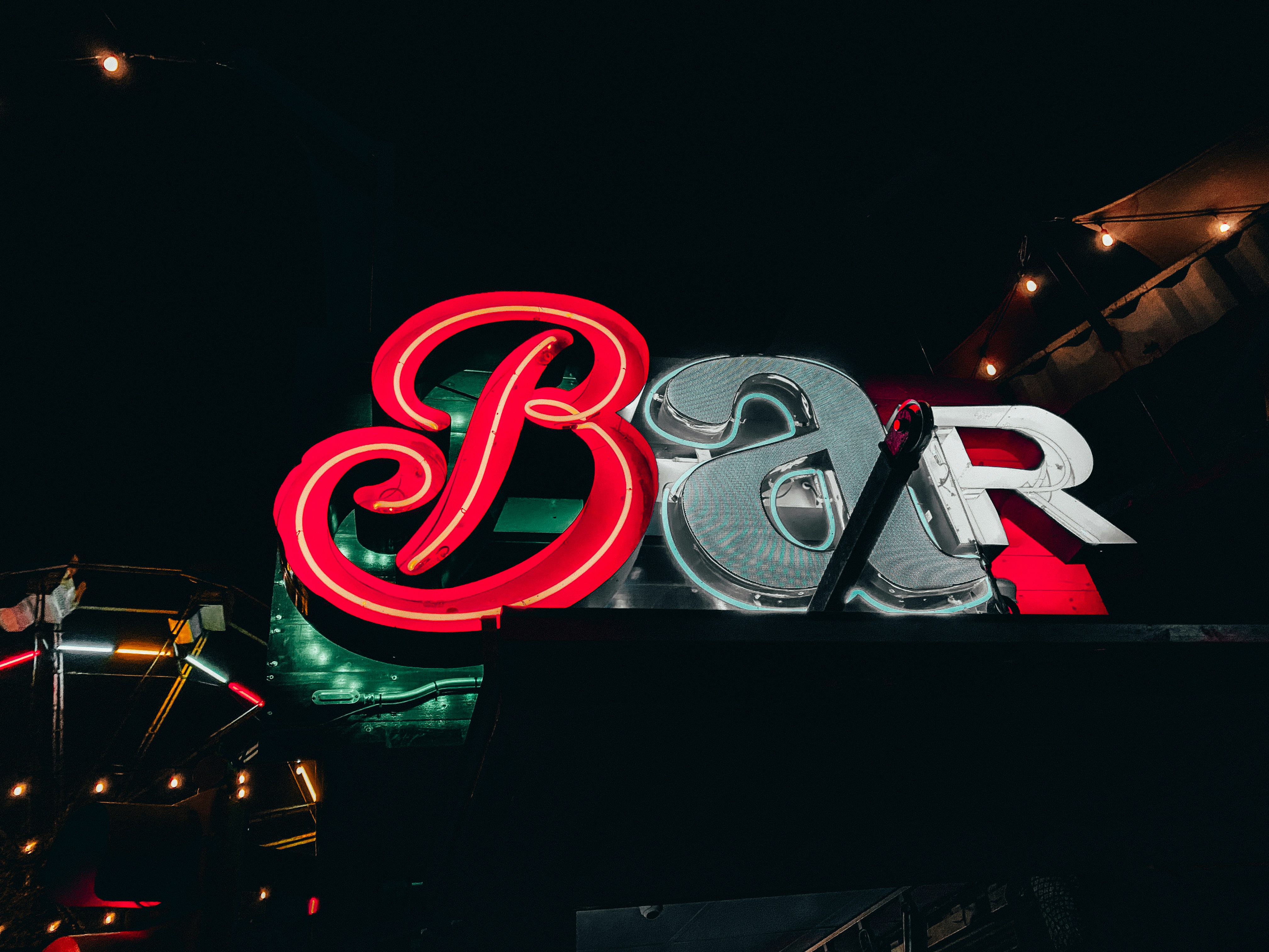 Neon-Burst Sign Spills Color Over Night Roofscape
