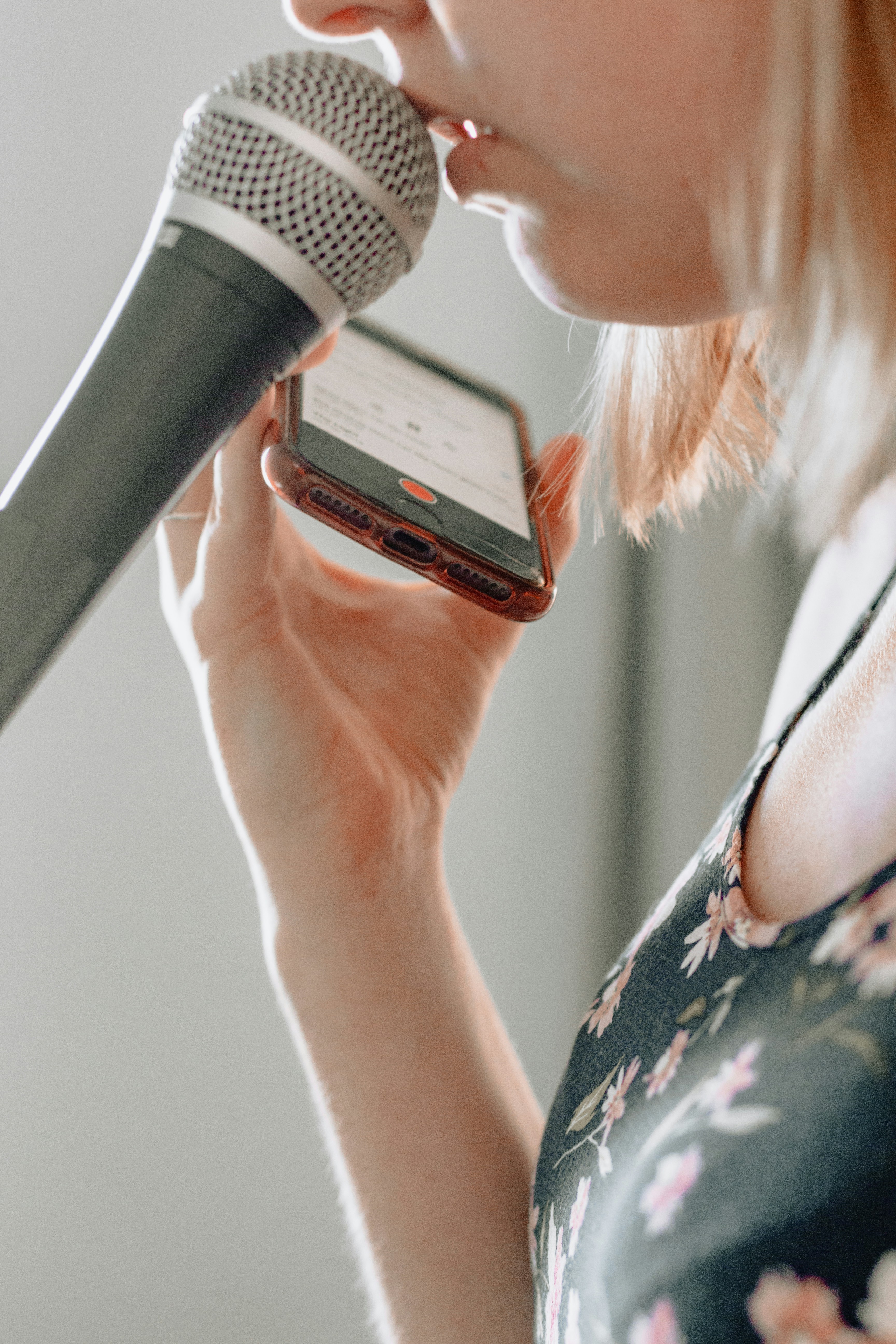 Woman holding iPhone with microphone on mouth photo – Free South africa ...
