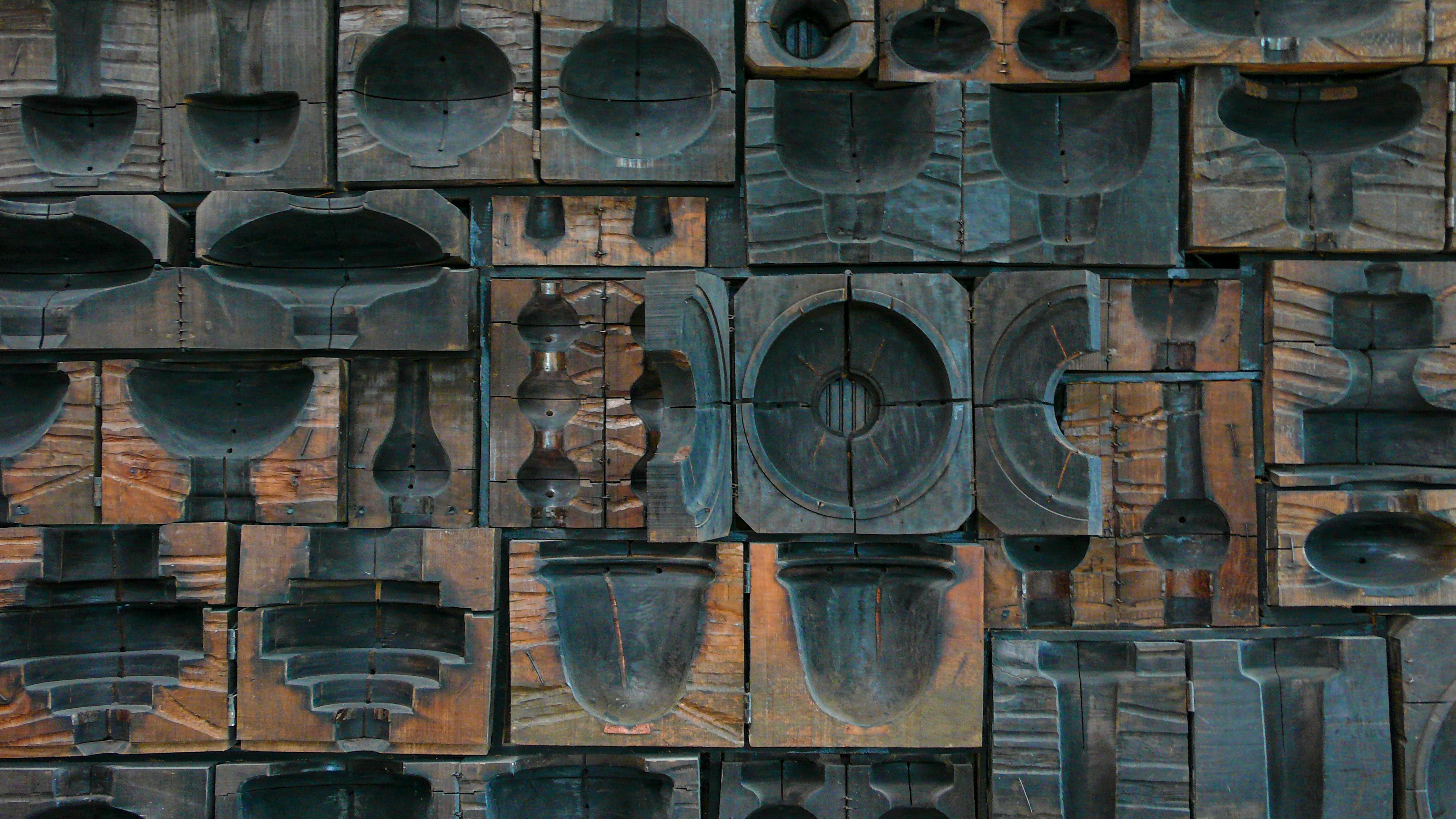 A collection of vintage wooden printing blocks arranged in a geometric pattern, showcasing diverse shapes and textures.