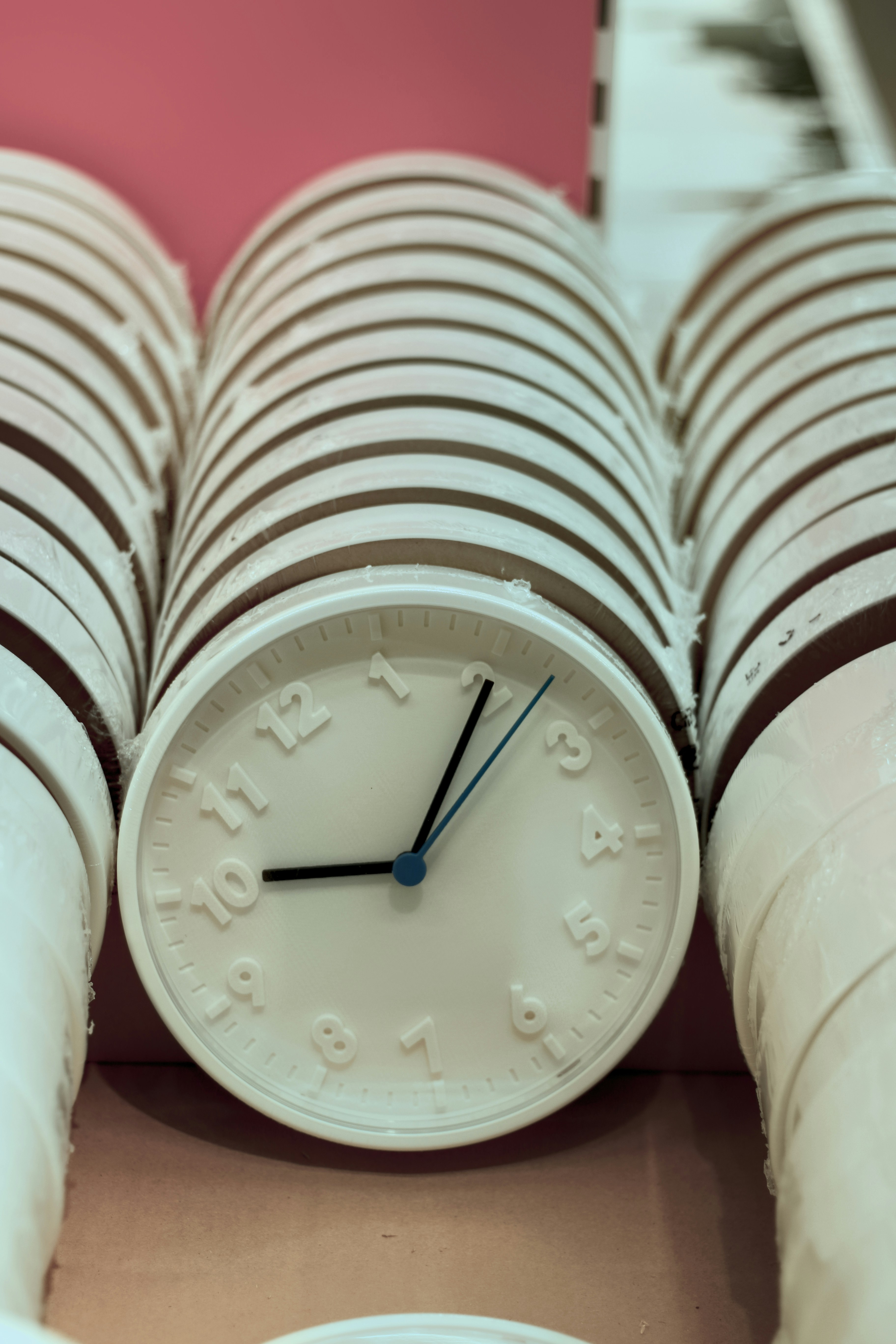 Time Ticks Between Rows: Clock Amidst Stacked Cups