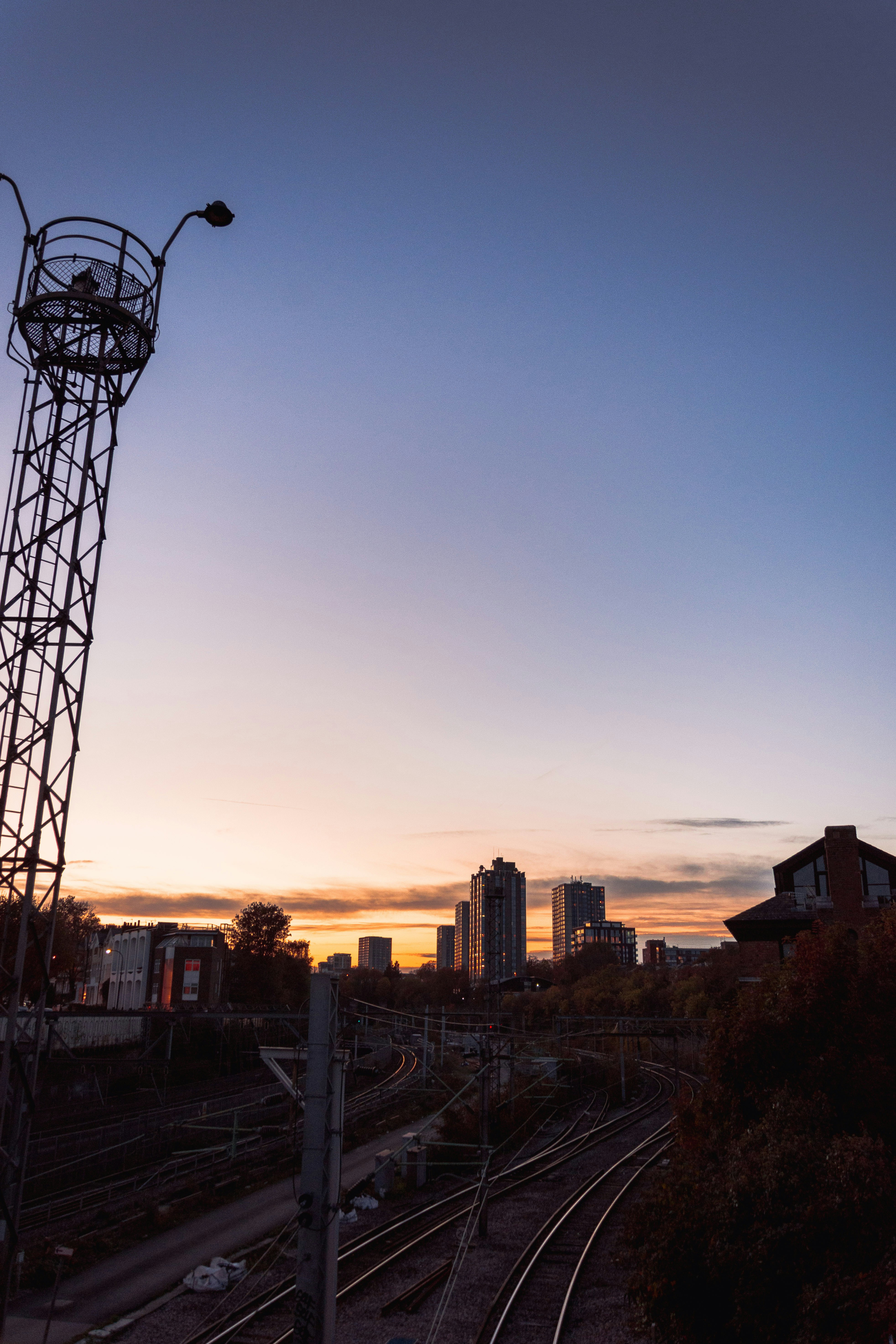 Dusk Convergence: Rails Framing a Quiet City Horizon