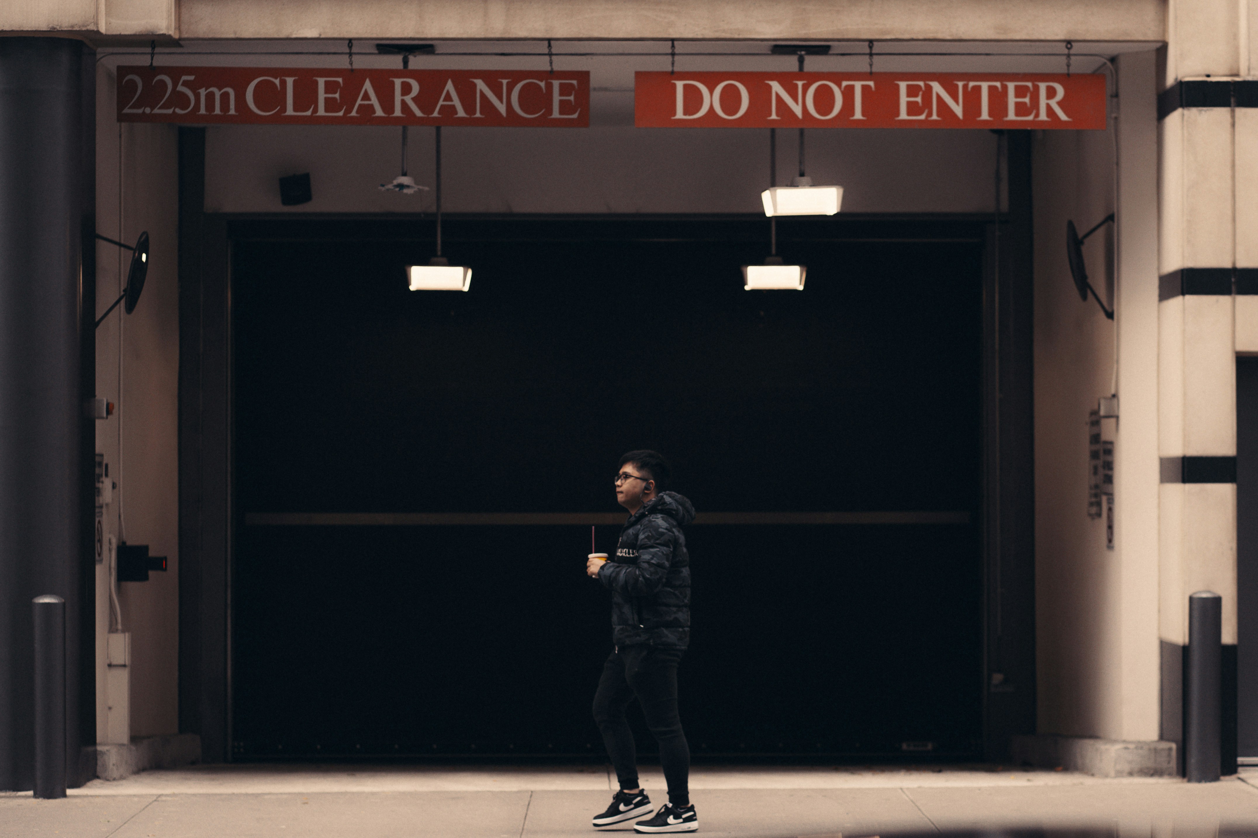 Stride in the Shade: A lone figure before the 2.25m clearance gate