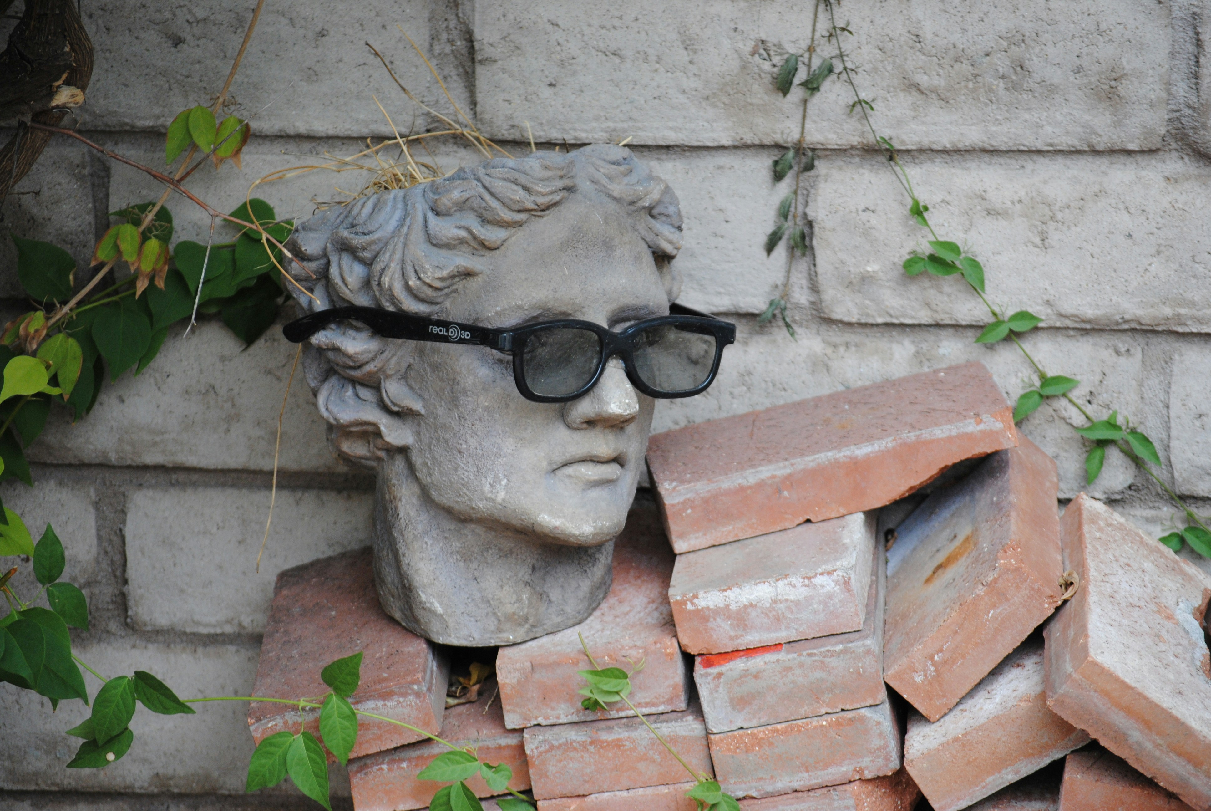 Gray concrete head bust on brown brick wall photo – Free Grey Image on ...
