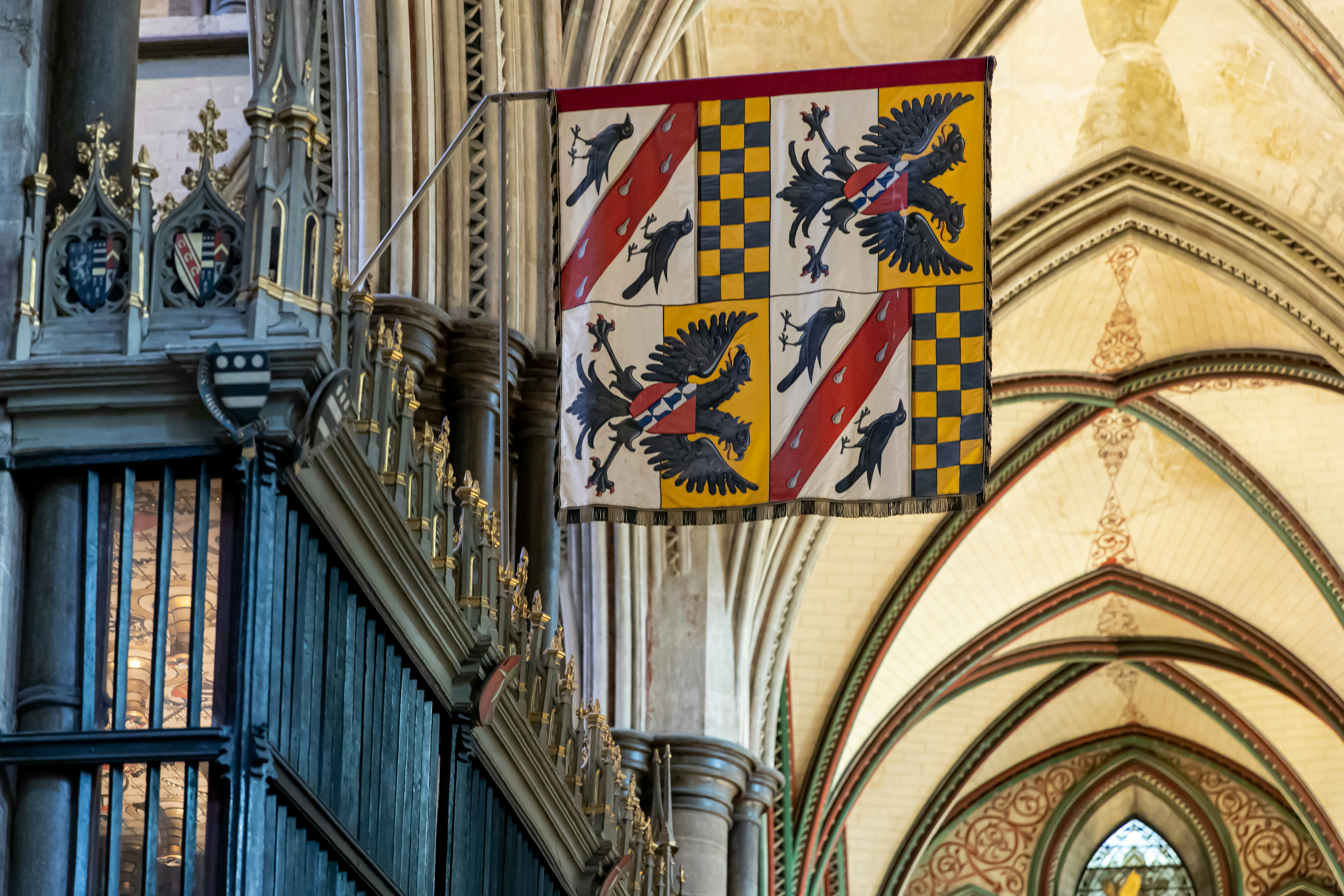 Heraldic Banner Above a Gothic Nave: Color and Emblems in Stone Vaults