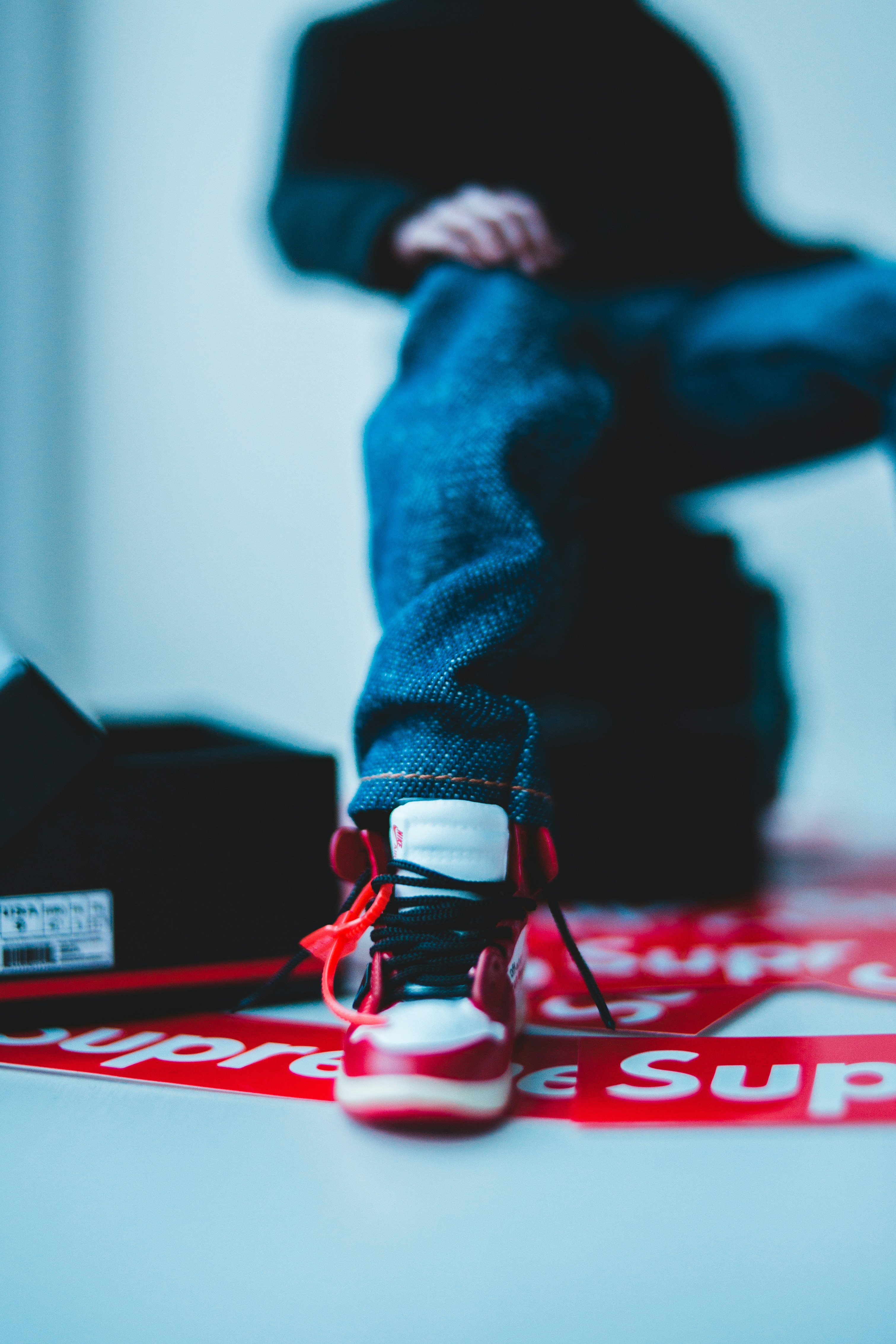 Close-Up of a Bold Sneakered Step atop a Red-Graphic Surface