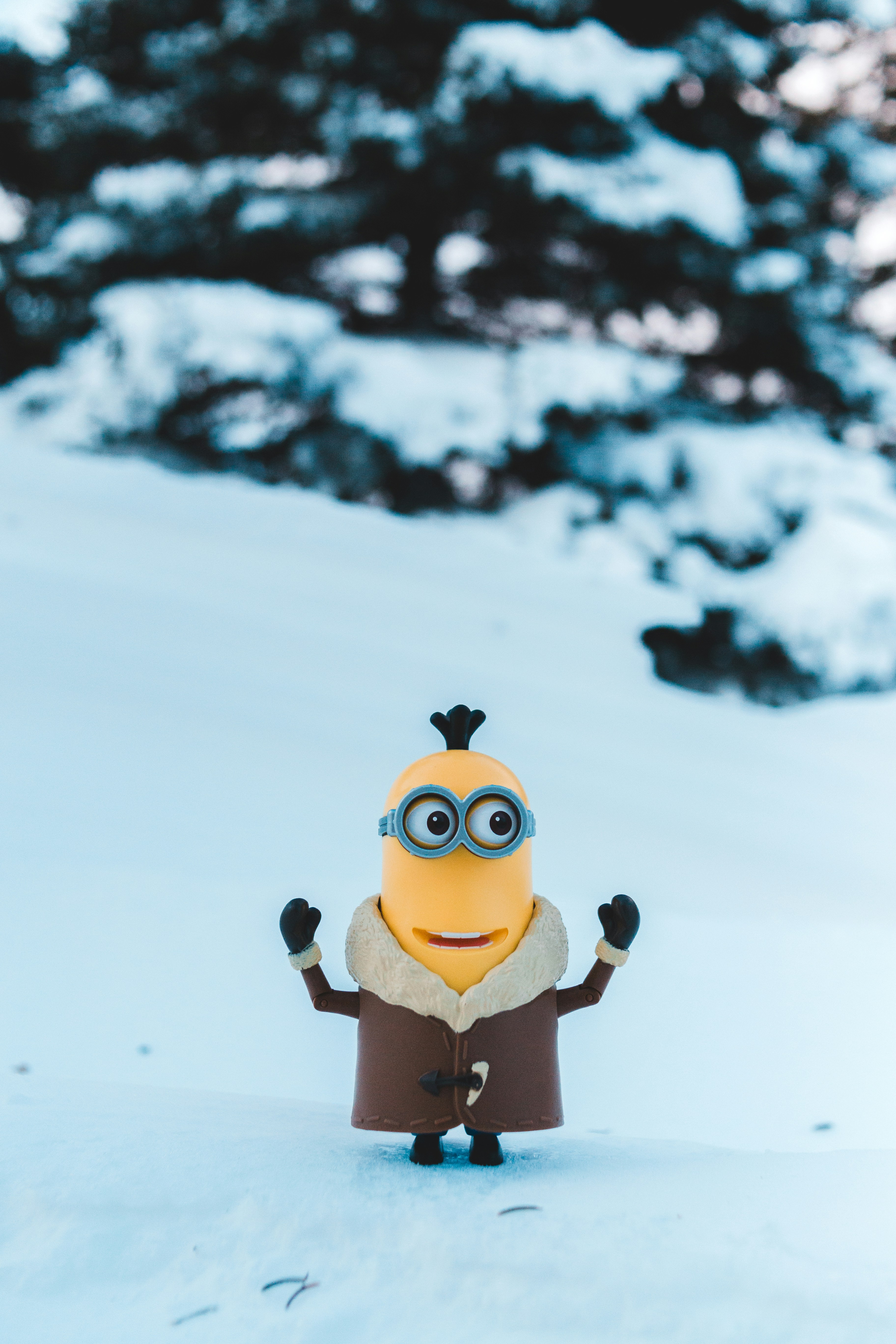 A toy figure of a minion standing in the snow photo – Free Mascot Image ...