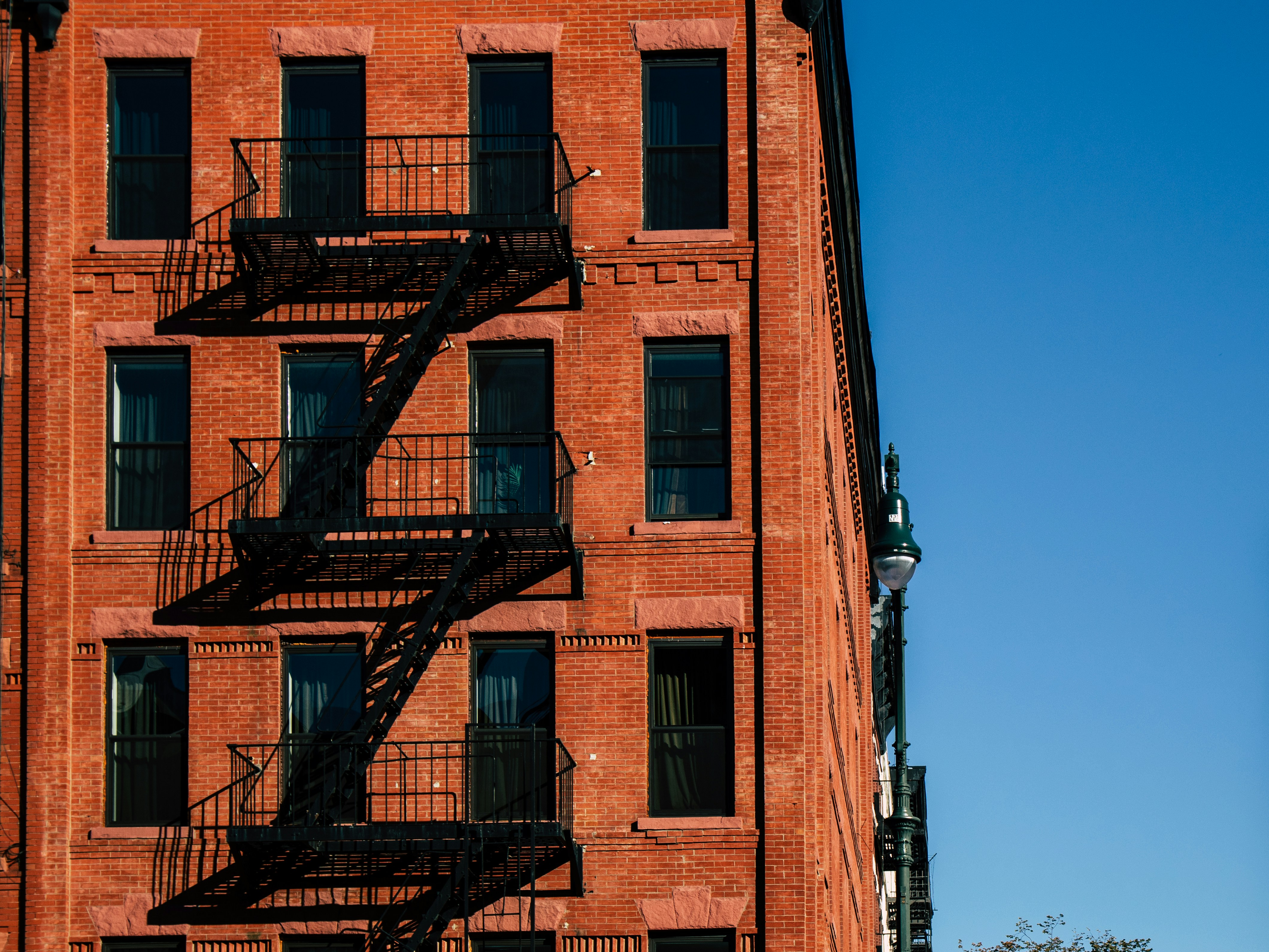 A tall brick building with a fire escape photo – Free Manhattan Image ...
