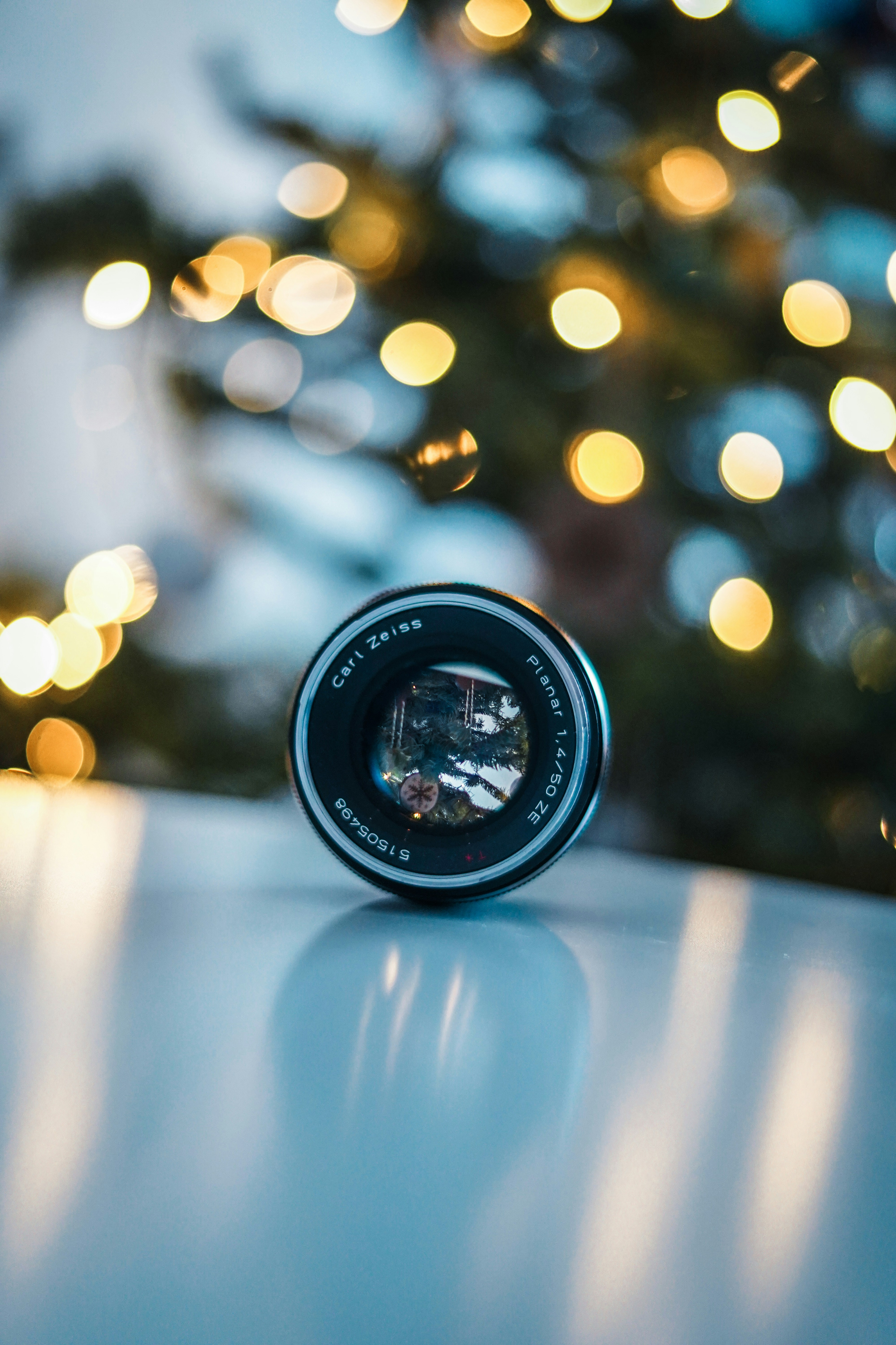 Tiny Zeiss Lens Meets Christmas Glow: Reflections on a Glossy Surface