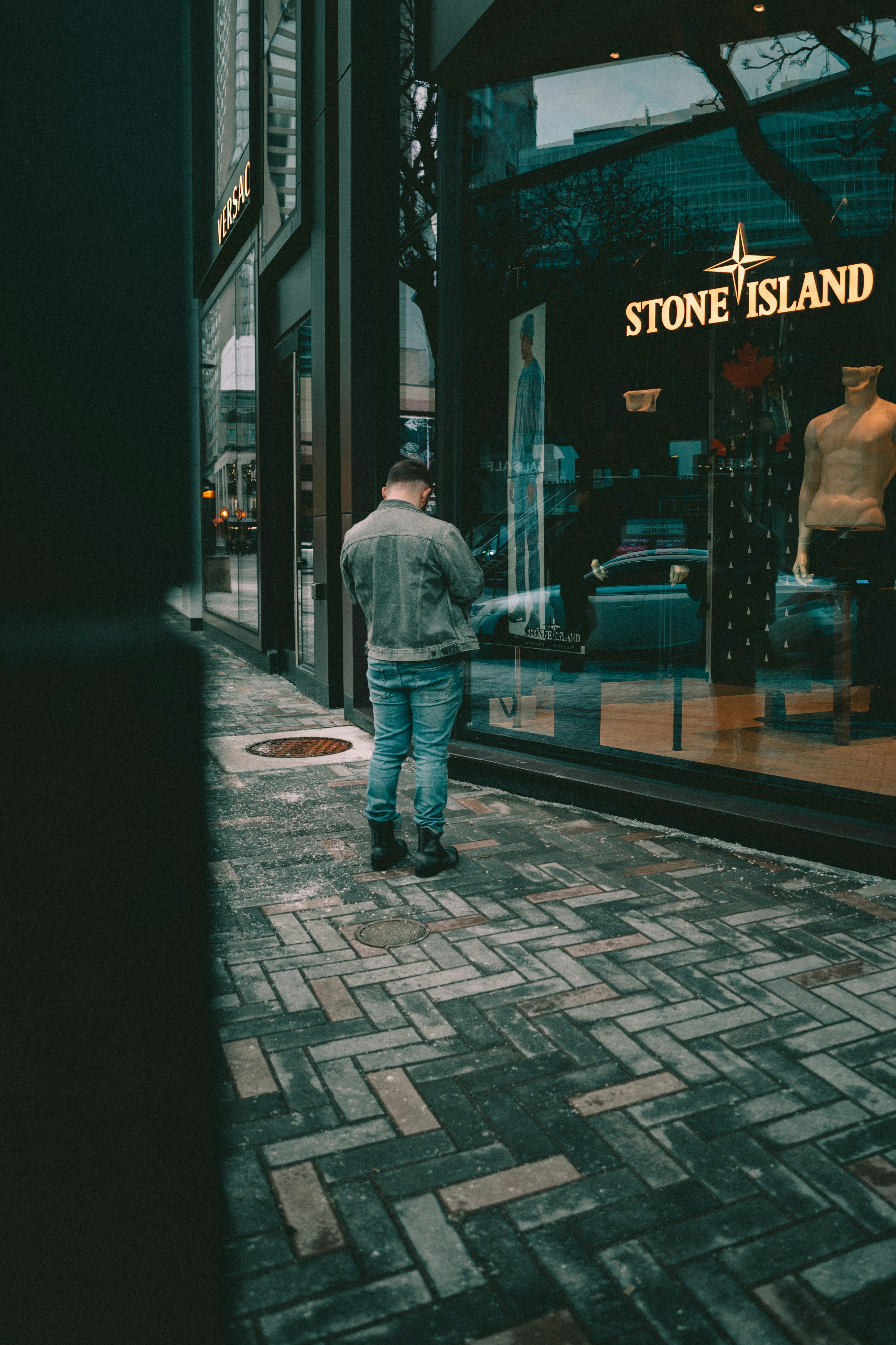 City Street Portrait: A Curious Moment Outside a Glass Storefront