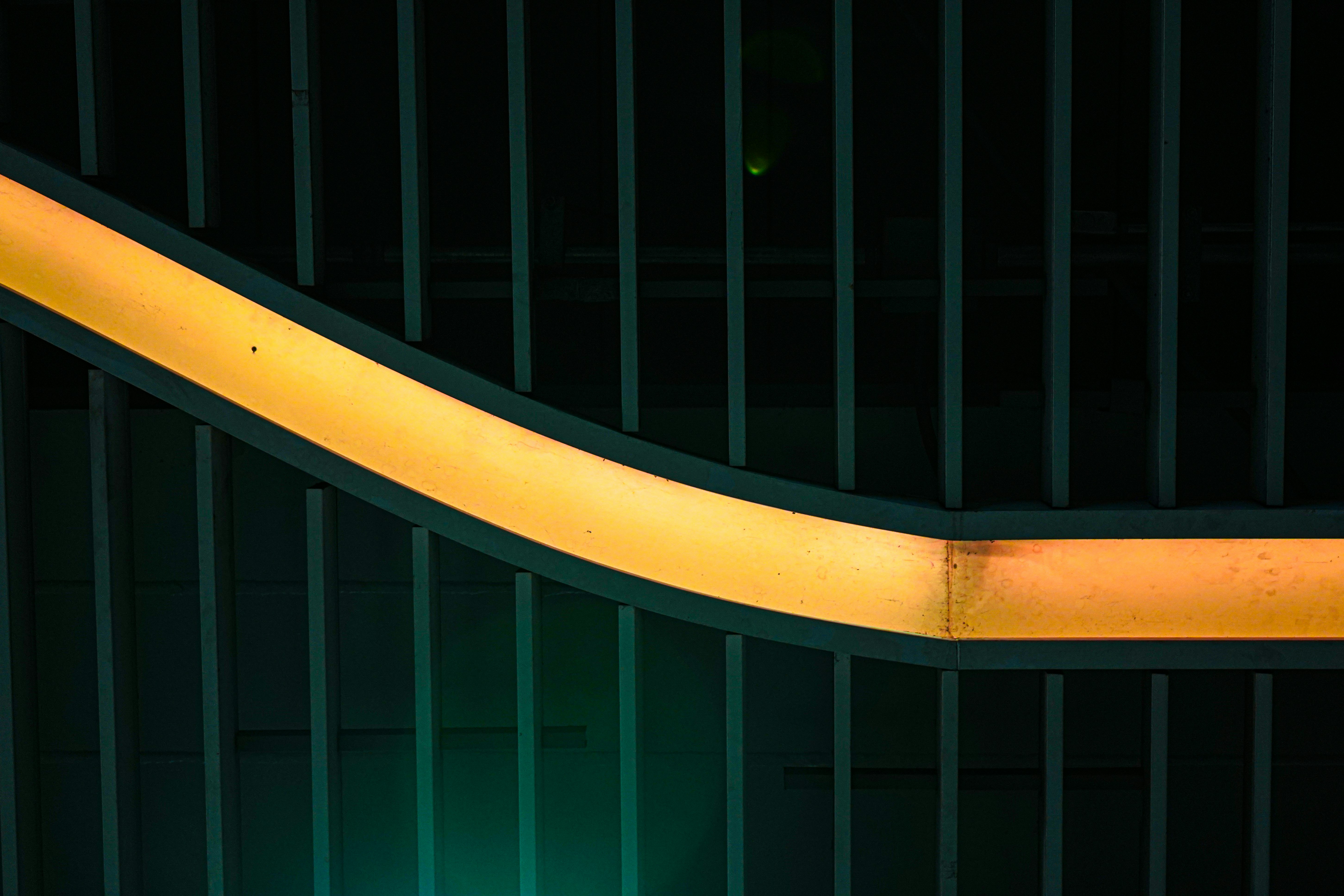 Curved fluorescent light casting a warm glow against dark vertical panels.