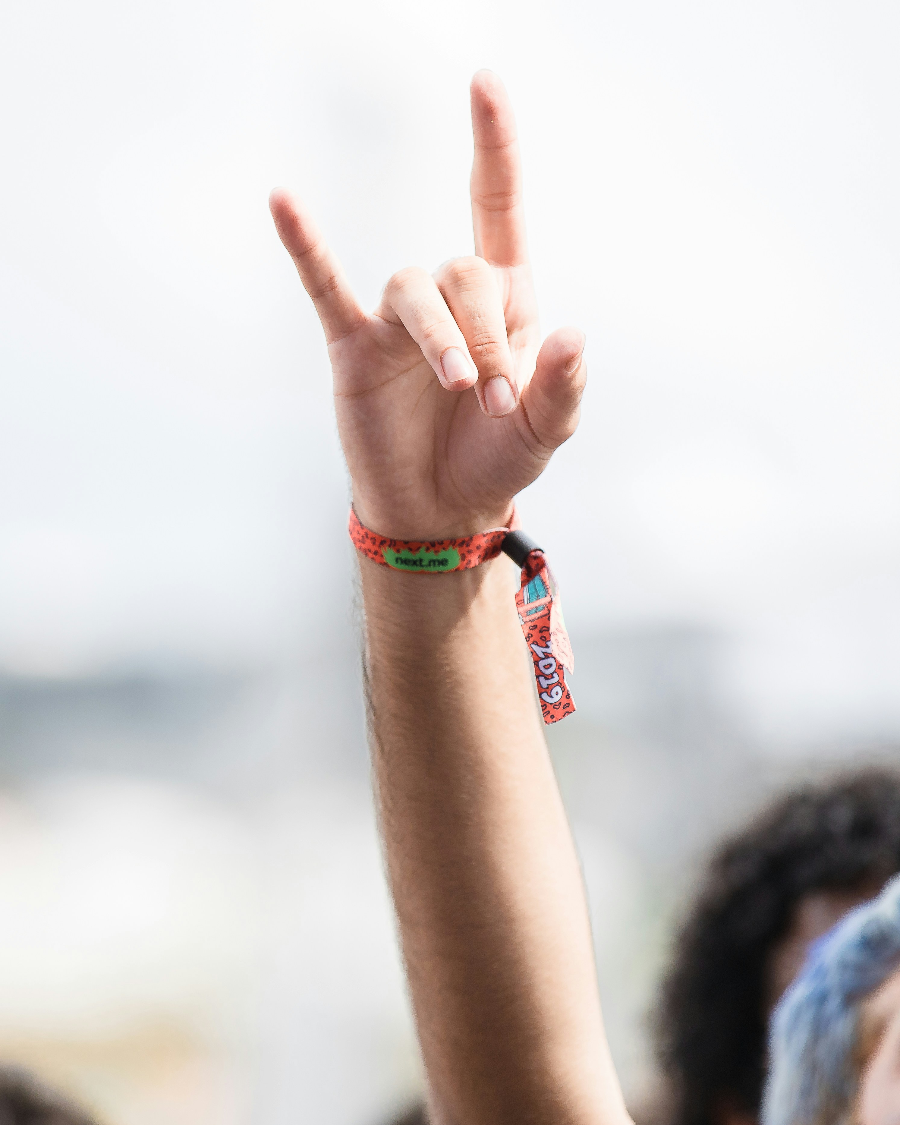 Signal and Wristband: A Close-Up of the Rock-On Gesture at a Festival